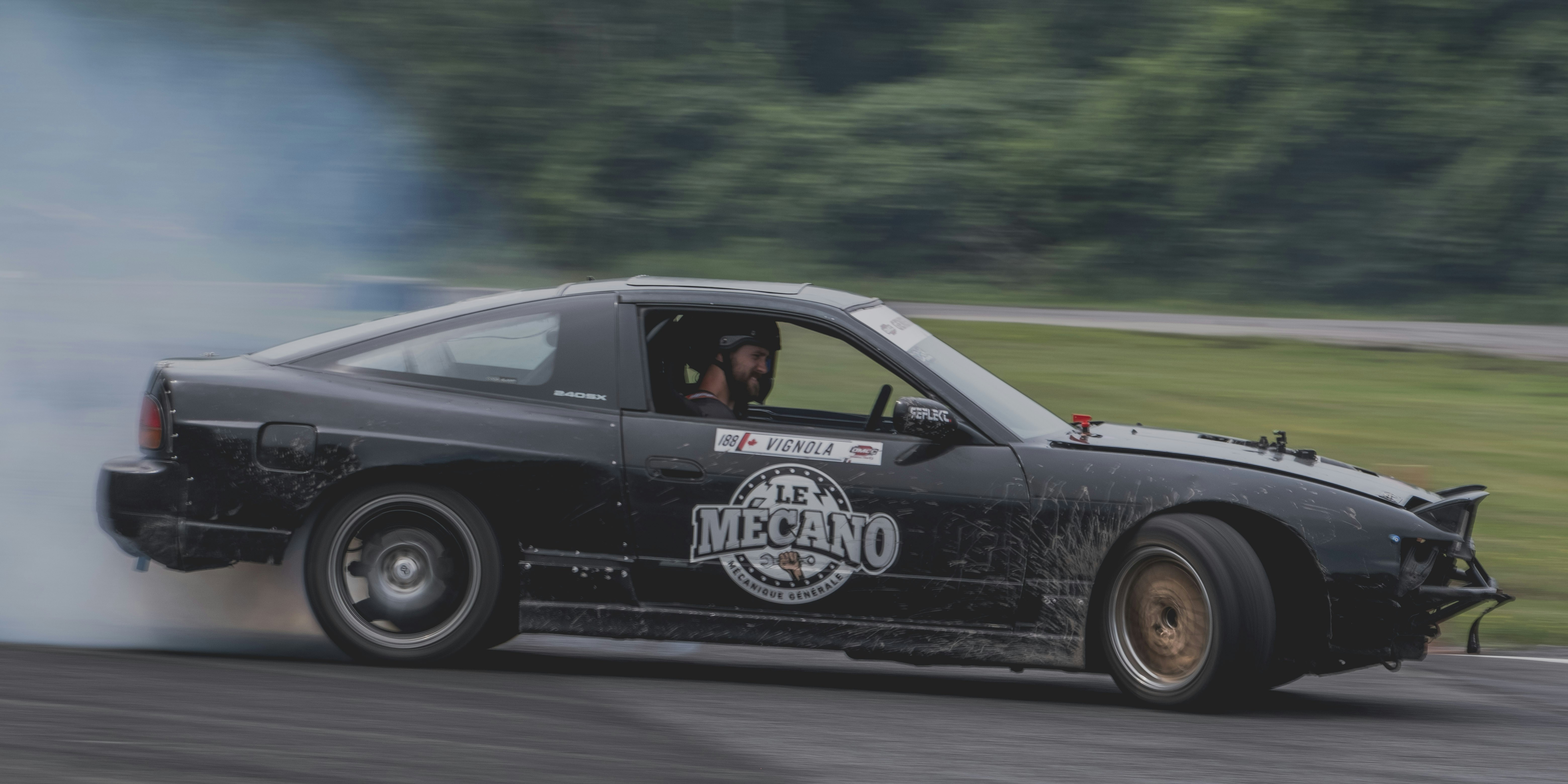 Mid-Drift Precision: Black Drift Muscle Car on a Smoke-Ringed Track