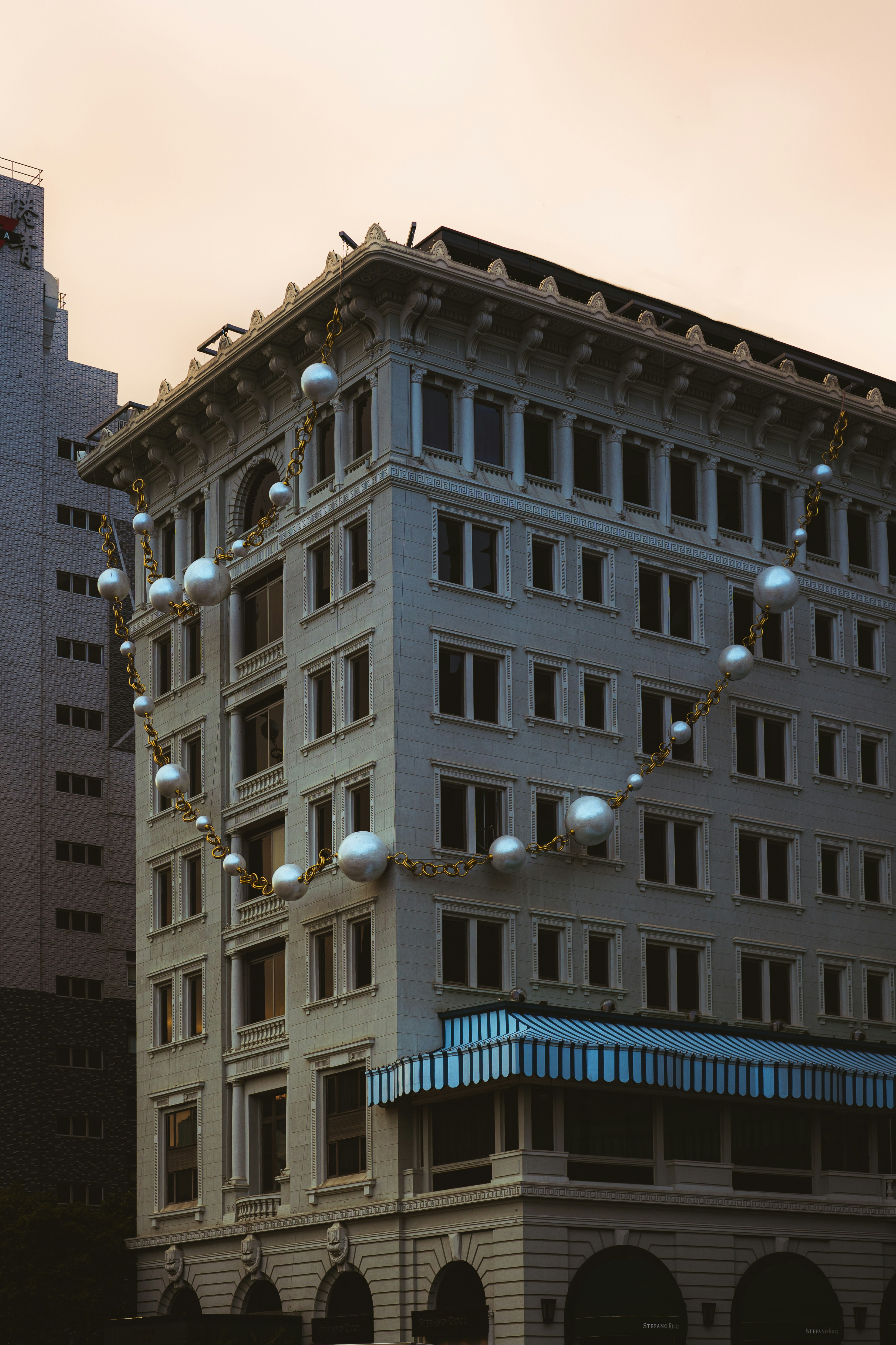 Beaded Skyline: A Facade Transformed by Silver Orbs and Gold Links