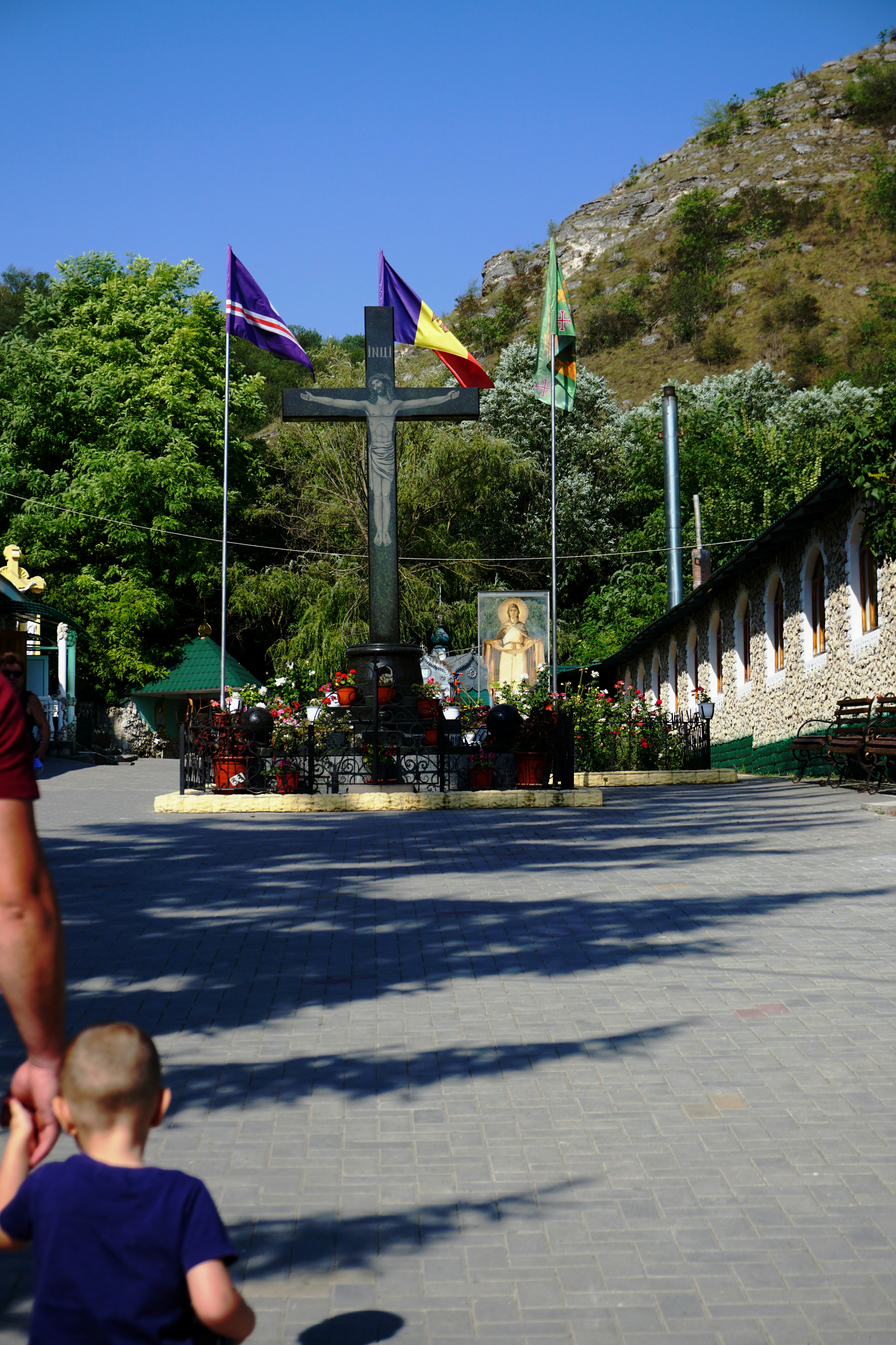 Sacred Pillar Plaza: A Shrine Framed by Flags and Shadowed Courtyard