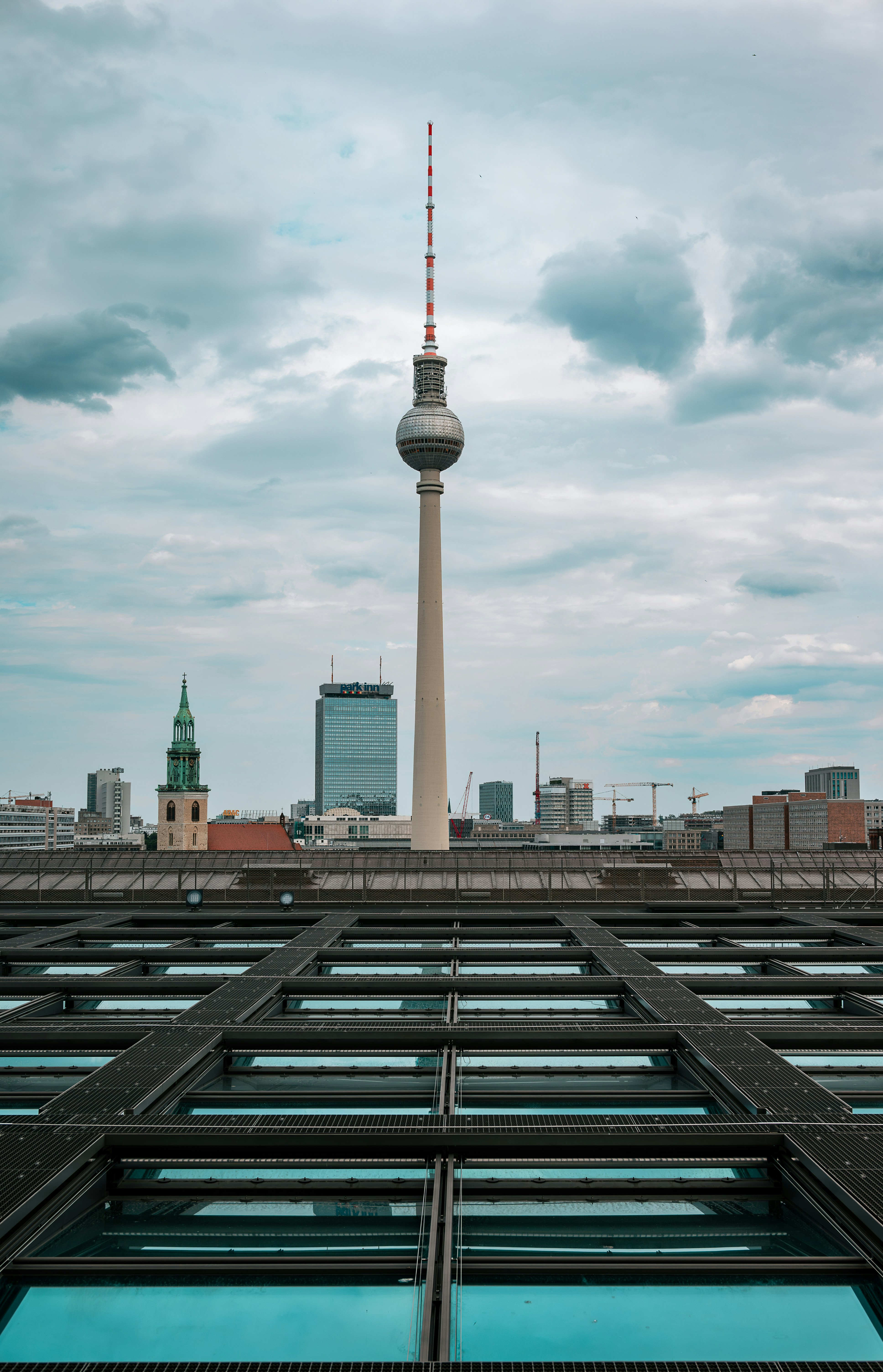 Rooftop Grid Framing Berlin's Fernsehturm Against a Moody Sky