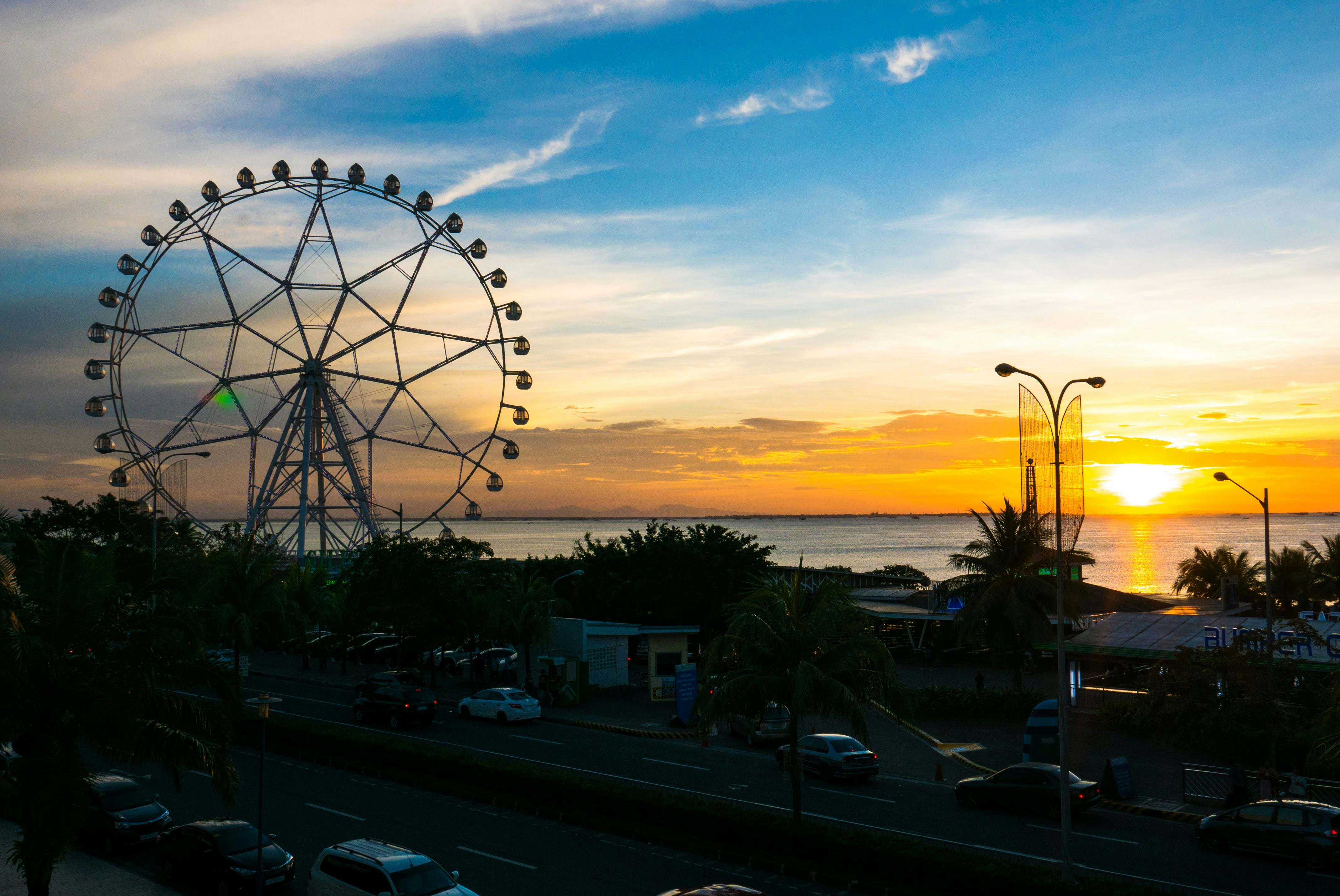 Coastal Sunset Silhouette: Ferris Wheel Against a Golden Horizon