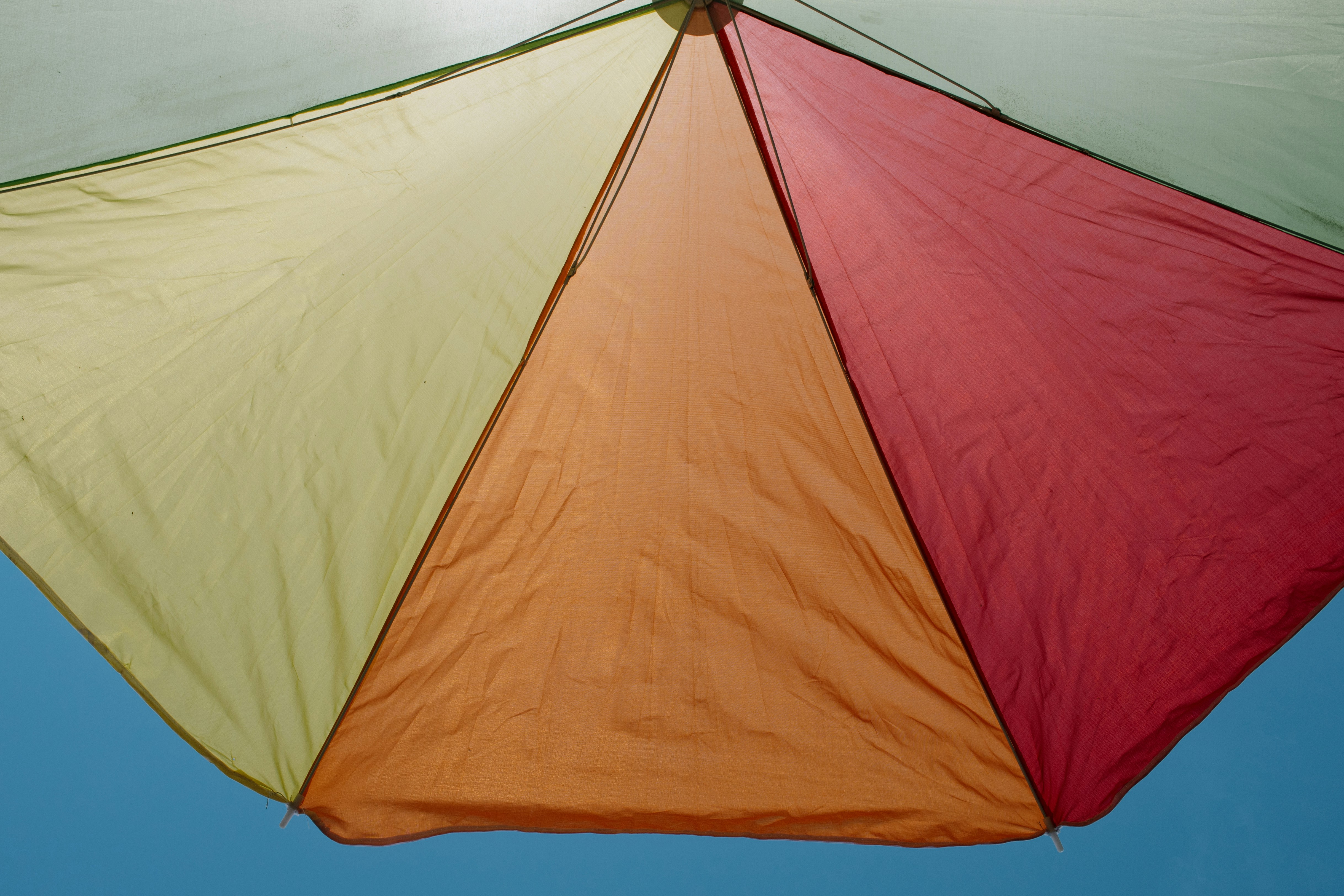 Apex of Color: Close-Up Under a Multicolored Umbrella Canopy