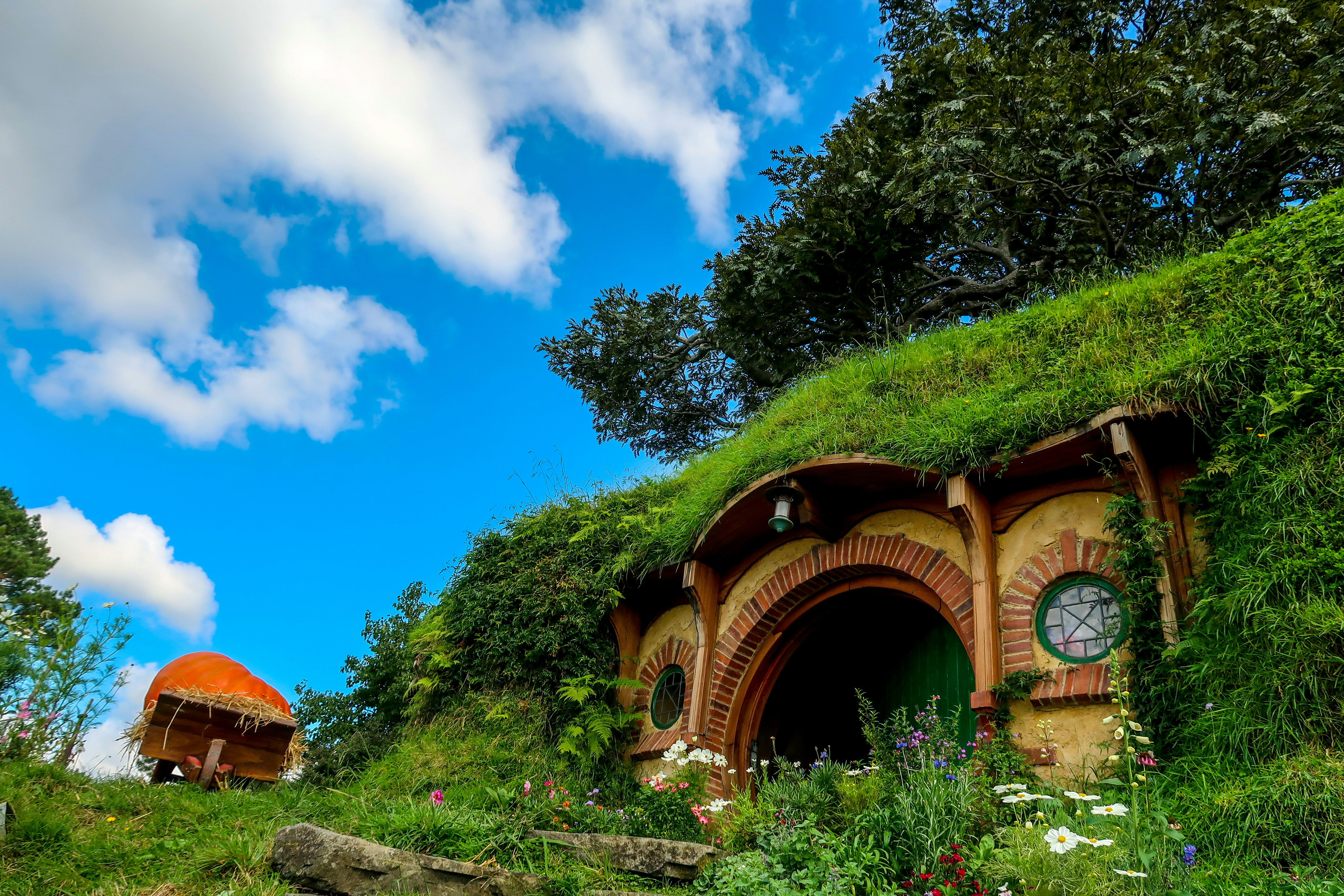 A hobbot house with a clock built into the side of it photo – Free ...