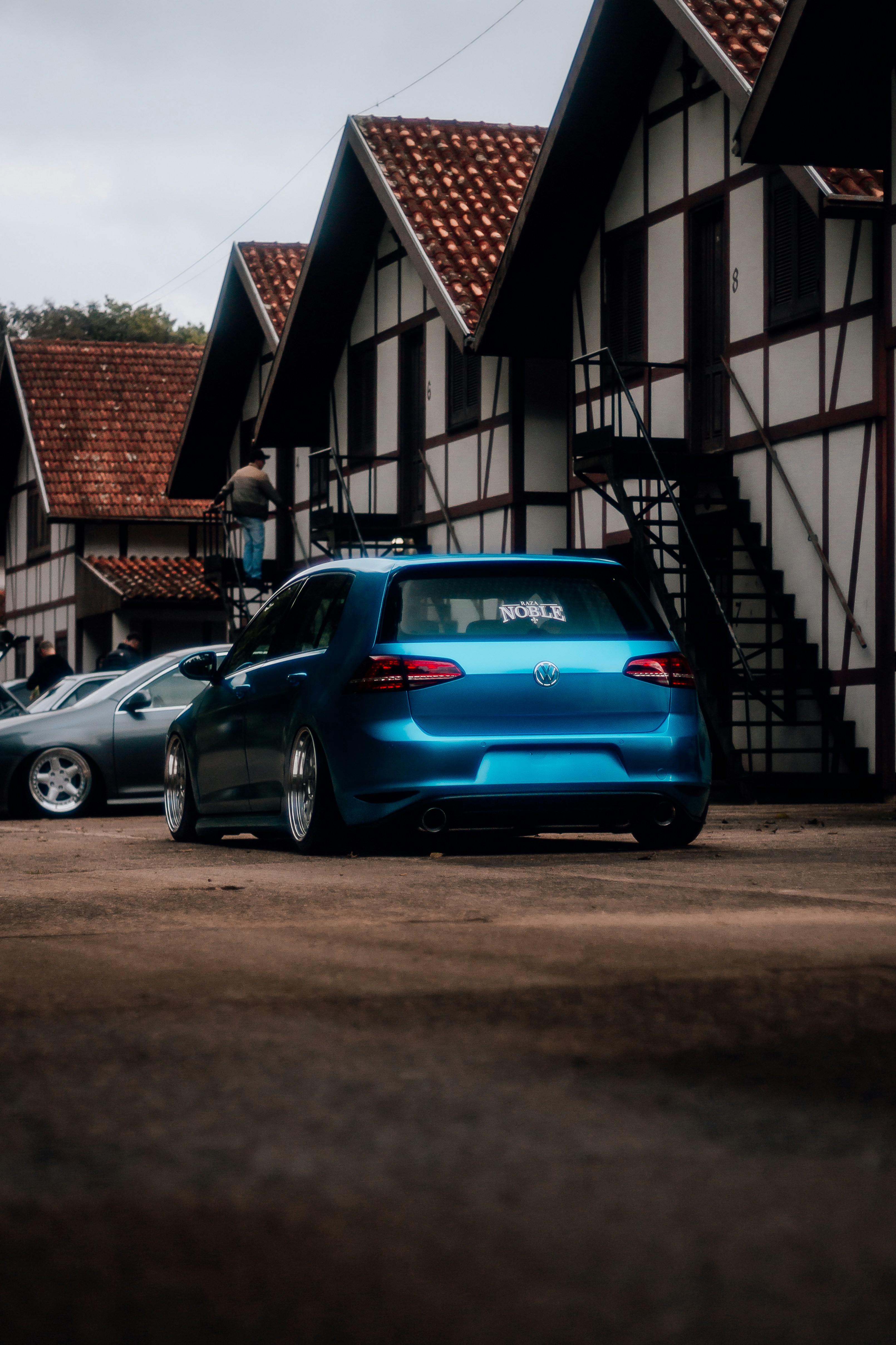 Blue Hatchback in a Row of Timber-Framed Buildings