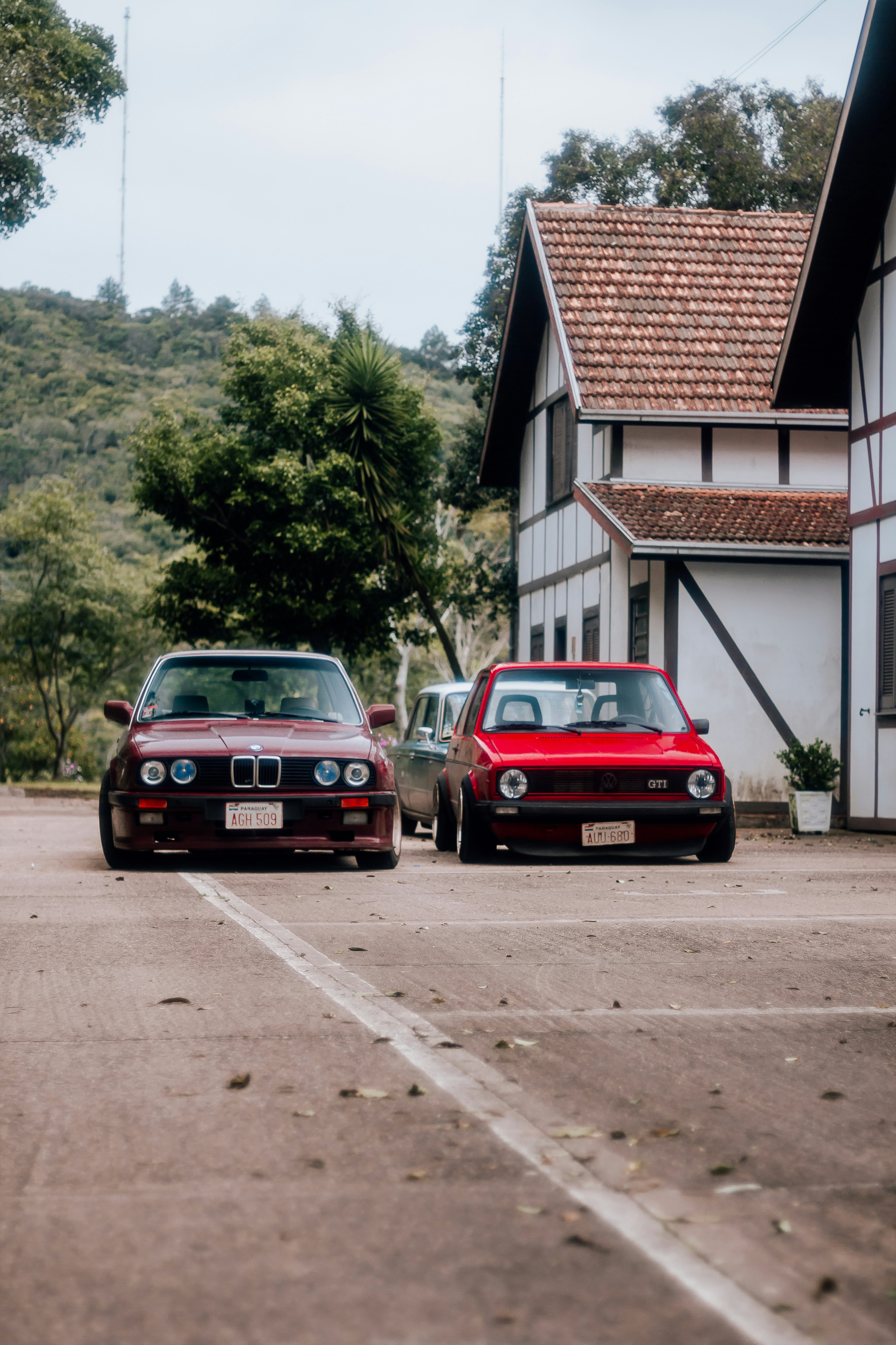 Two Retro Hatchbacks Parked in Front of a Quarter-Timbered Building