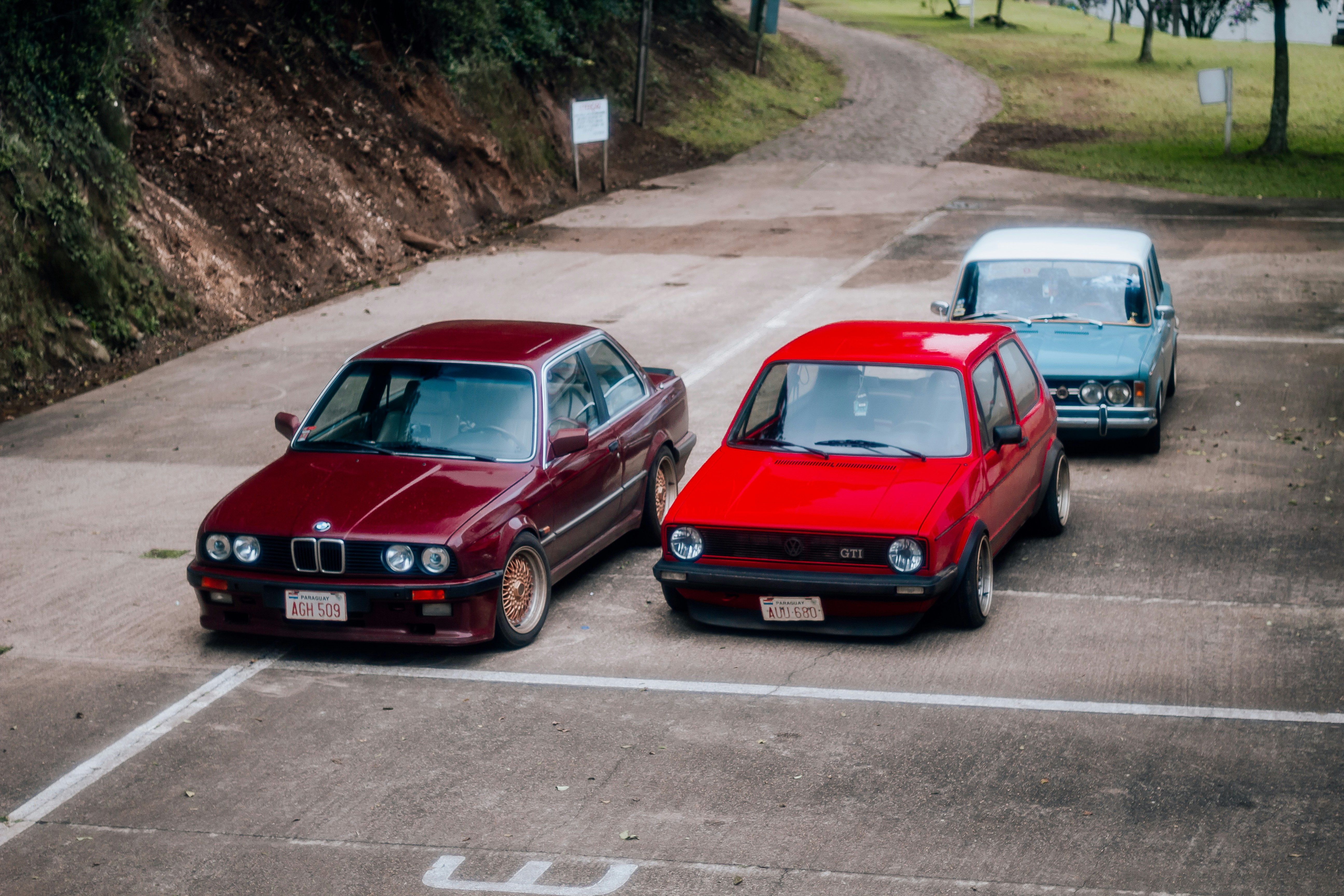 Tres autos estacionados en un estacionamiento uno al lado del otro foto ...
