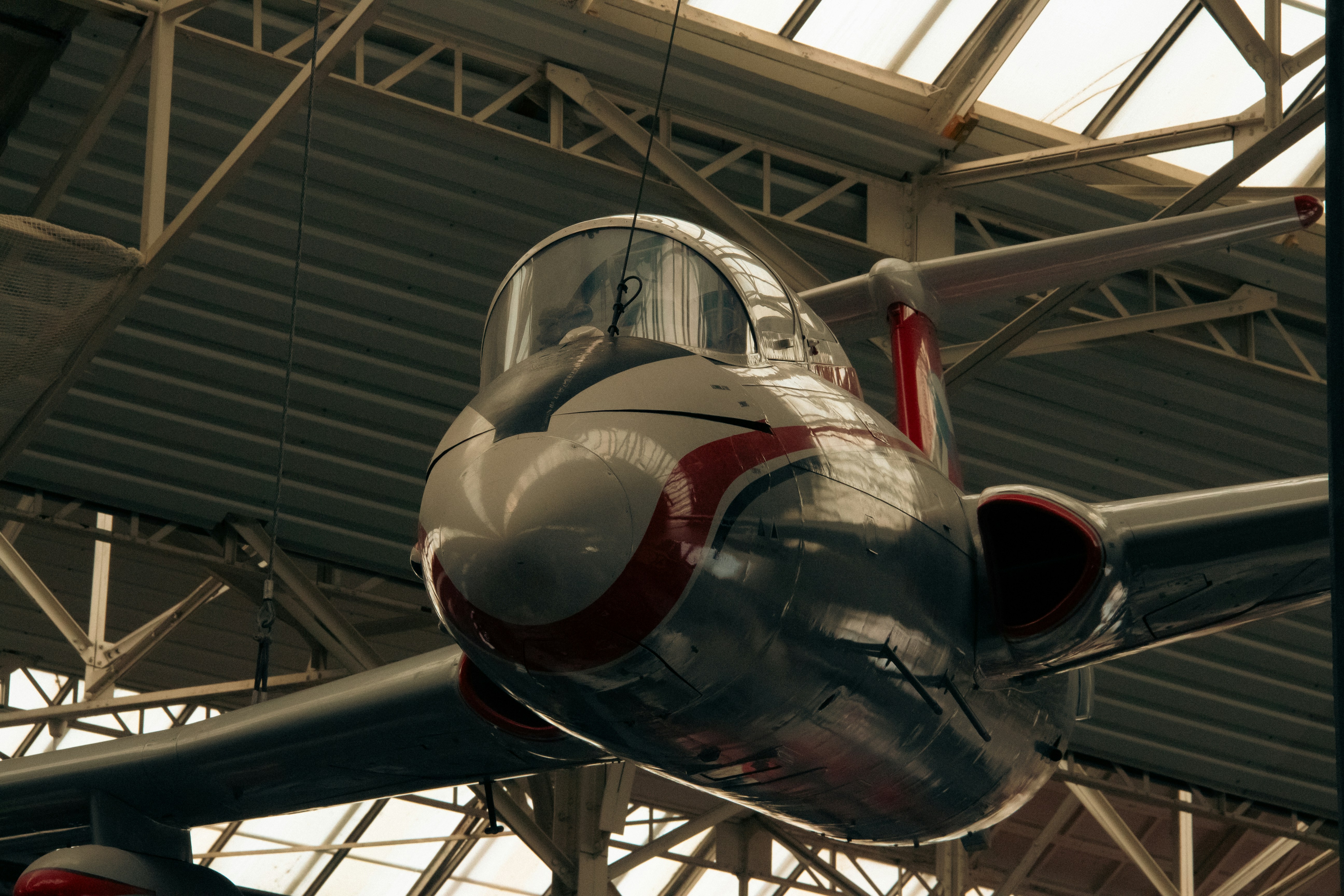 Nose of Time: A Vintage Aircraft Resting Beneath an Industrial Glass Canopy
