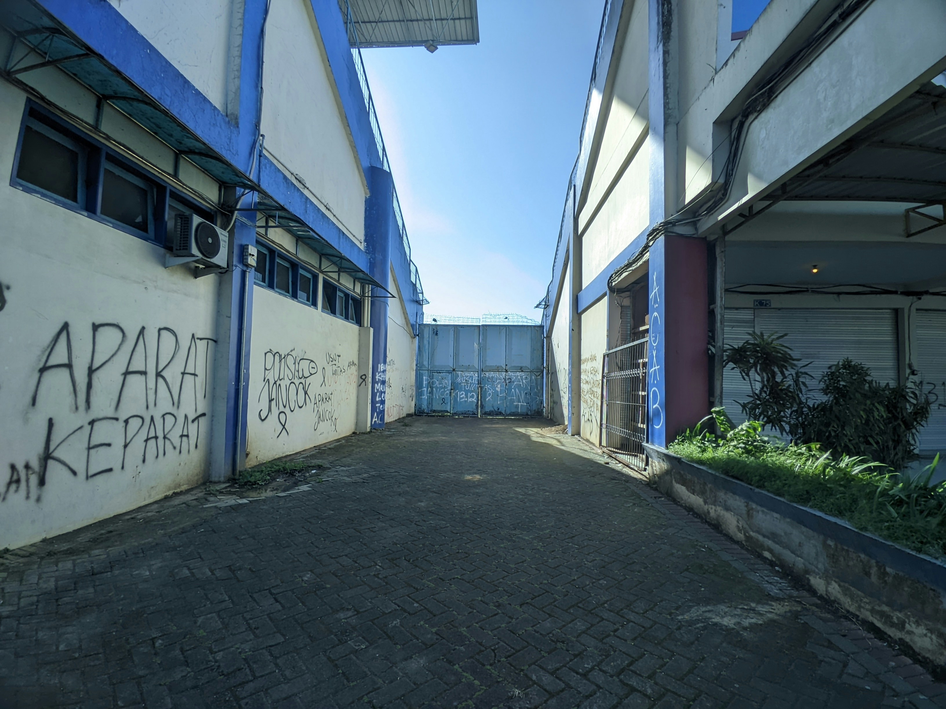 Toward the Gate: Symmetry, Graffiti, and Sunlit Industrial Quiet