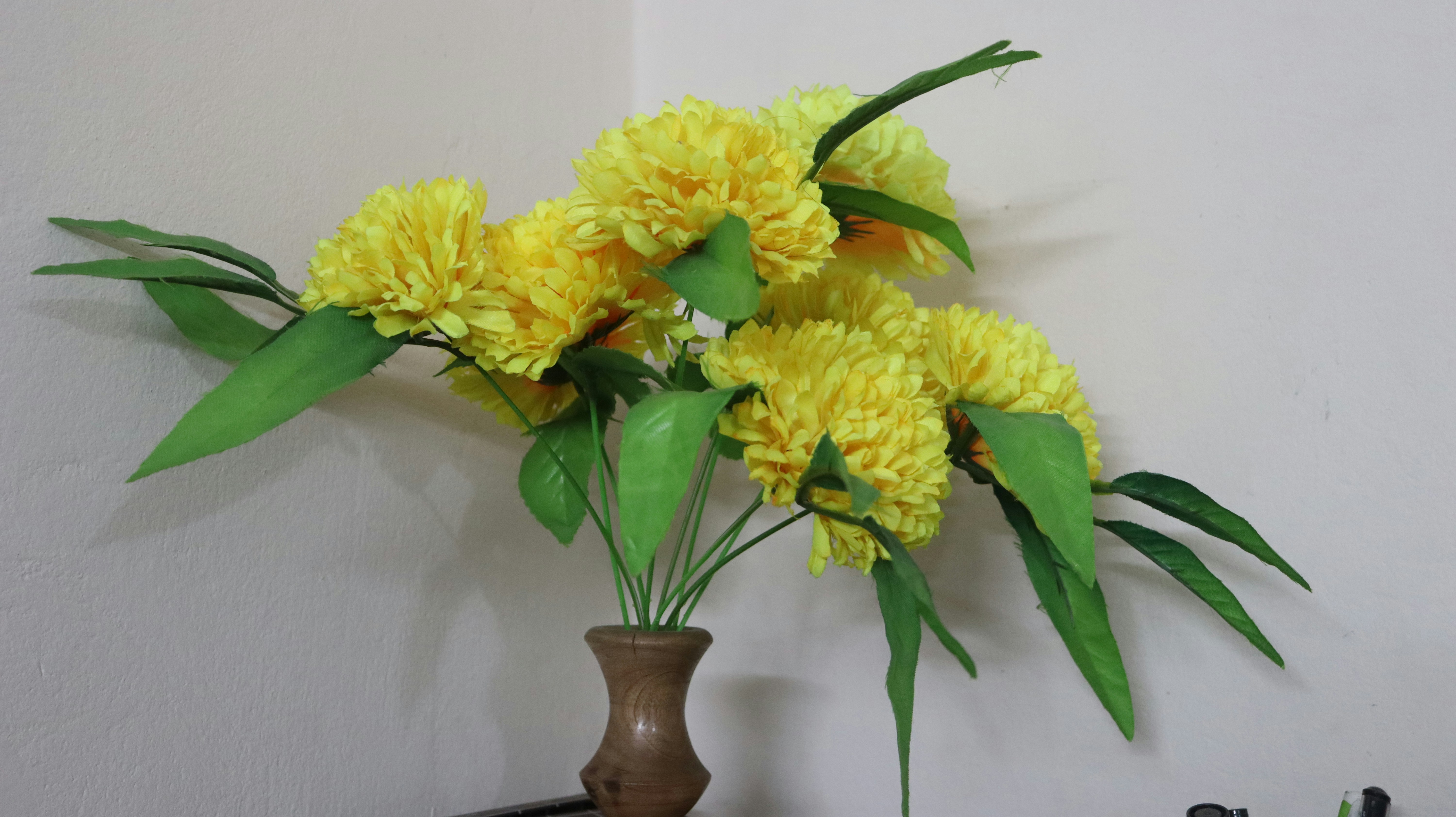Golden Chrysanthemums in a Ceramic Vase: Quiet Arrangement by the Wall