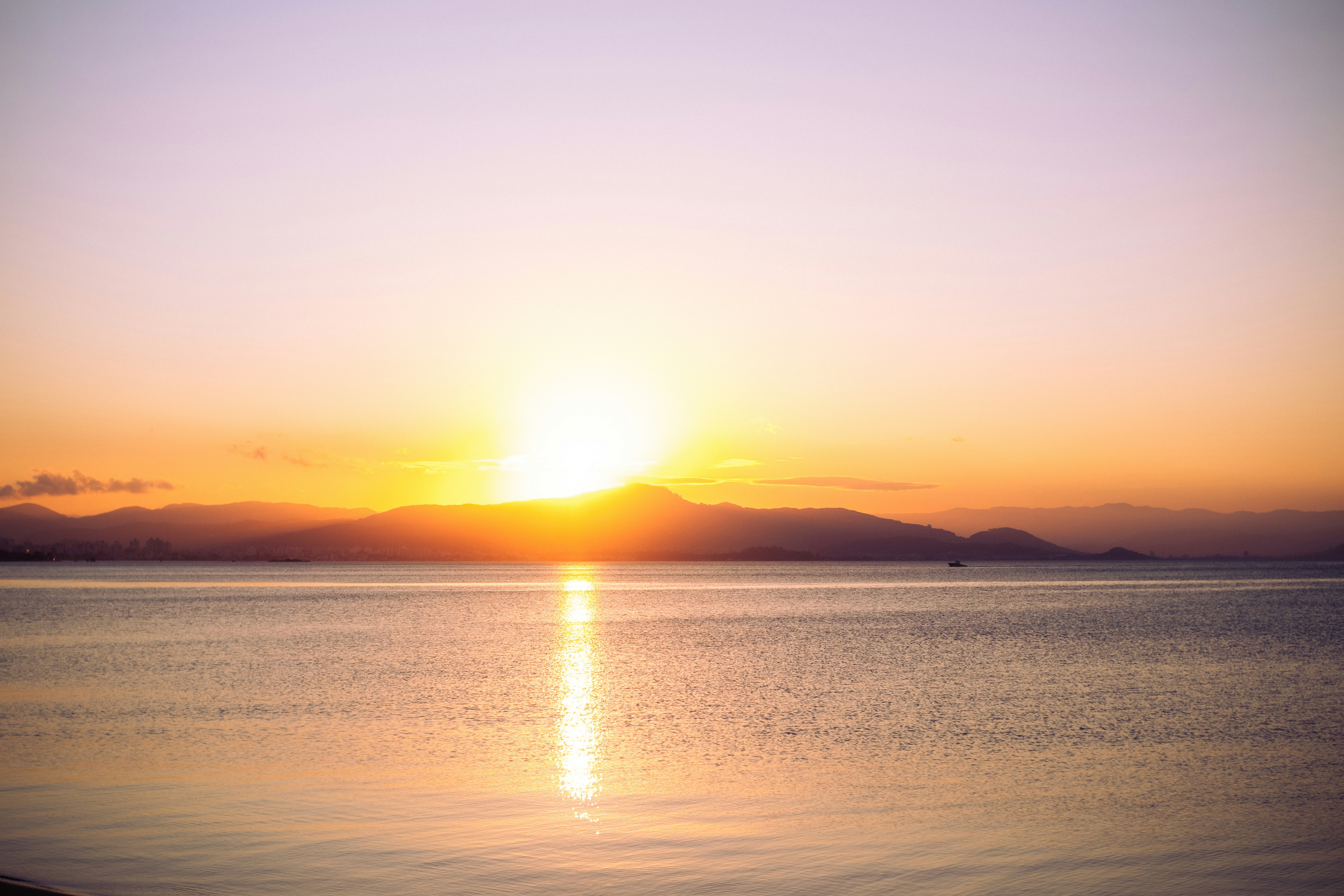 The sun is setting over a body of water photo – Free Sunrise Image on ...