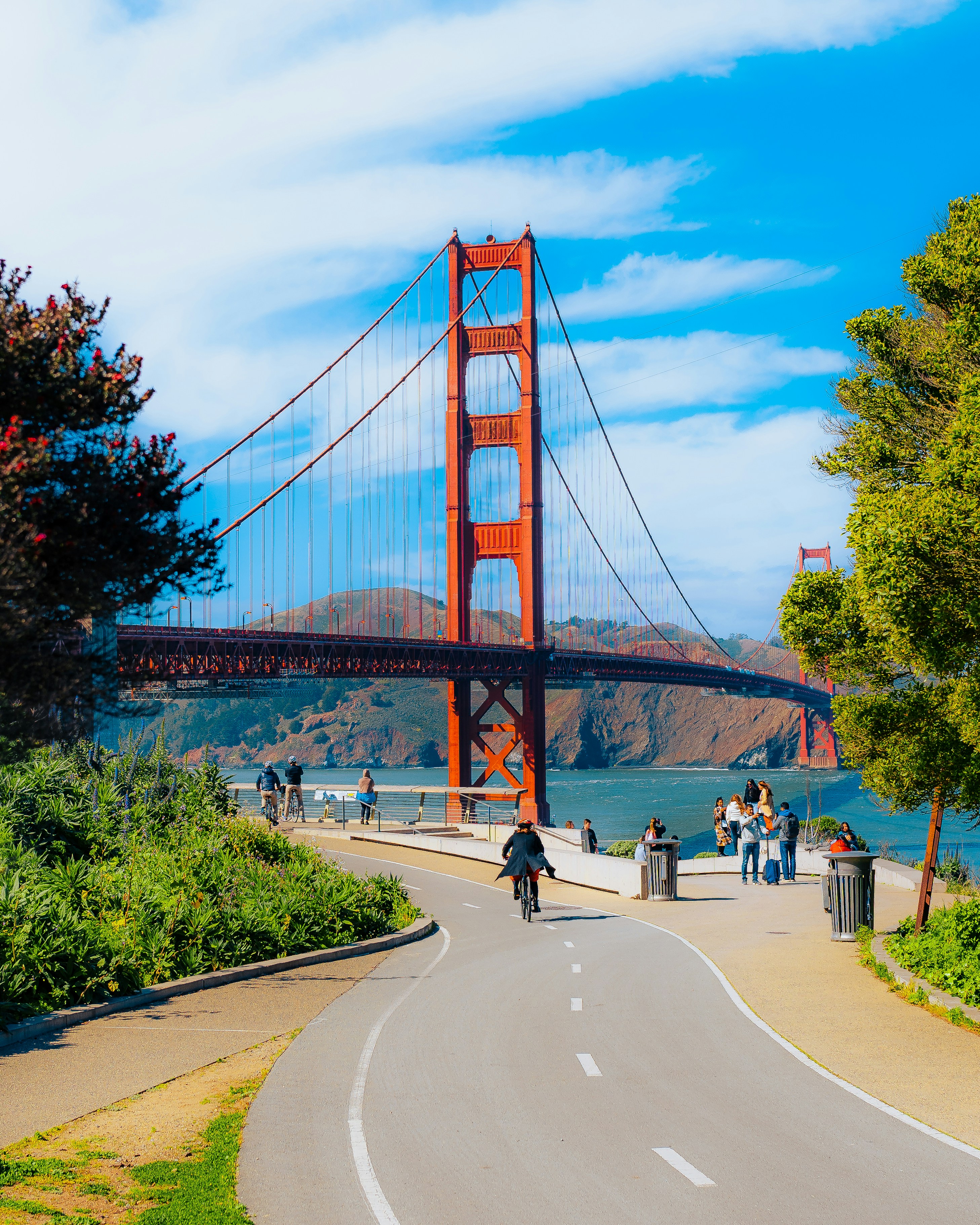 Sunlit Promenade Toward the Red Tower of the Golden Gate Bridge