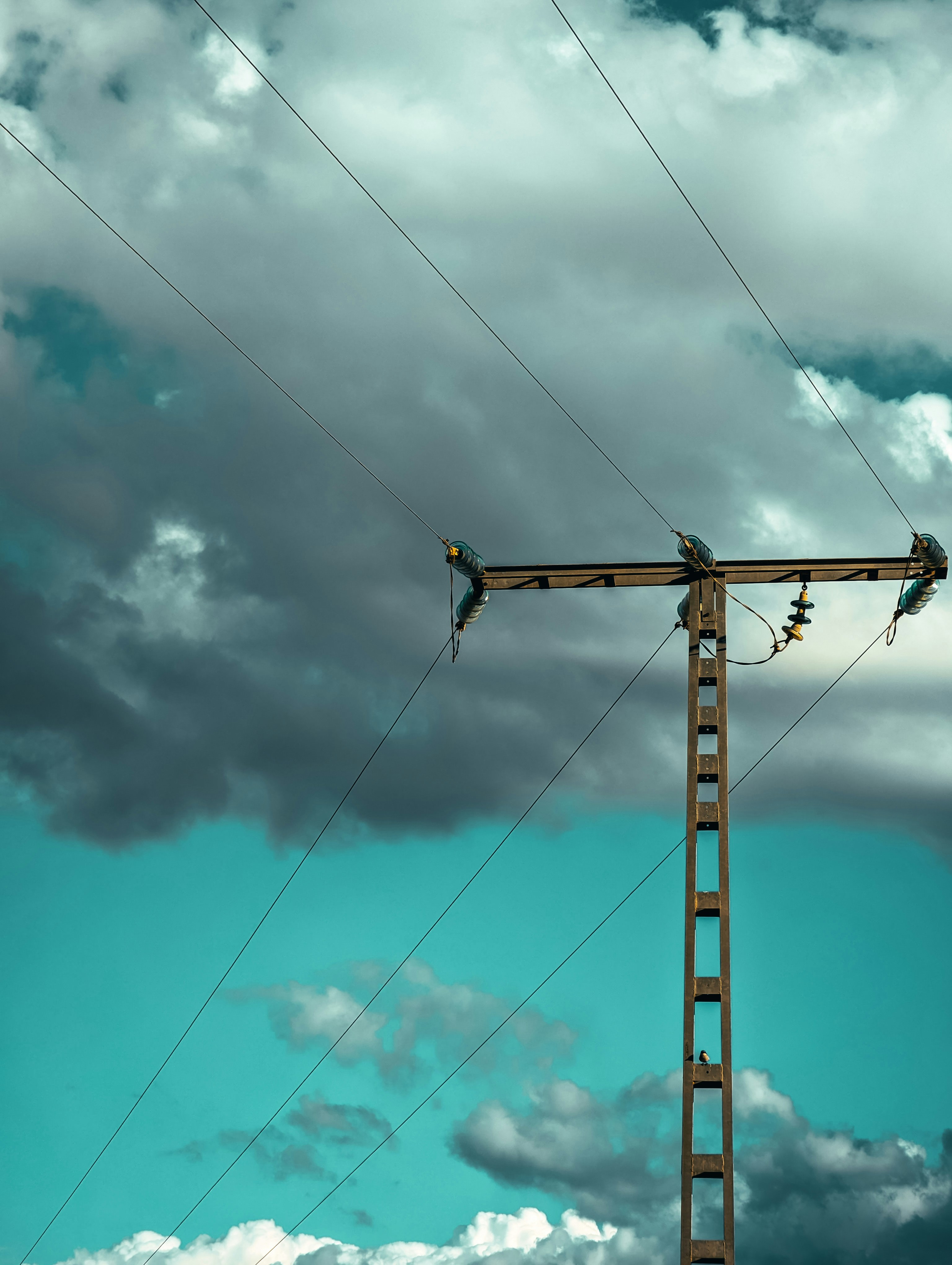 Lone Cross-Arm Against a Teal Sky