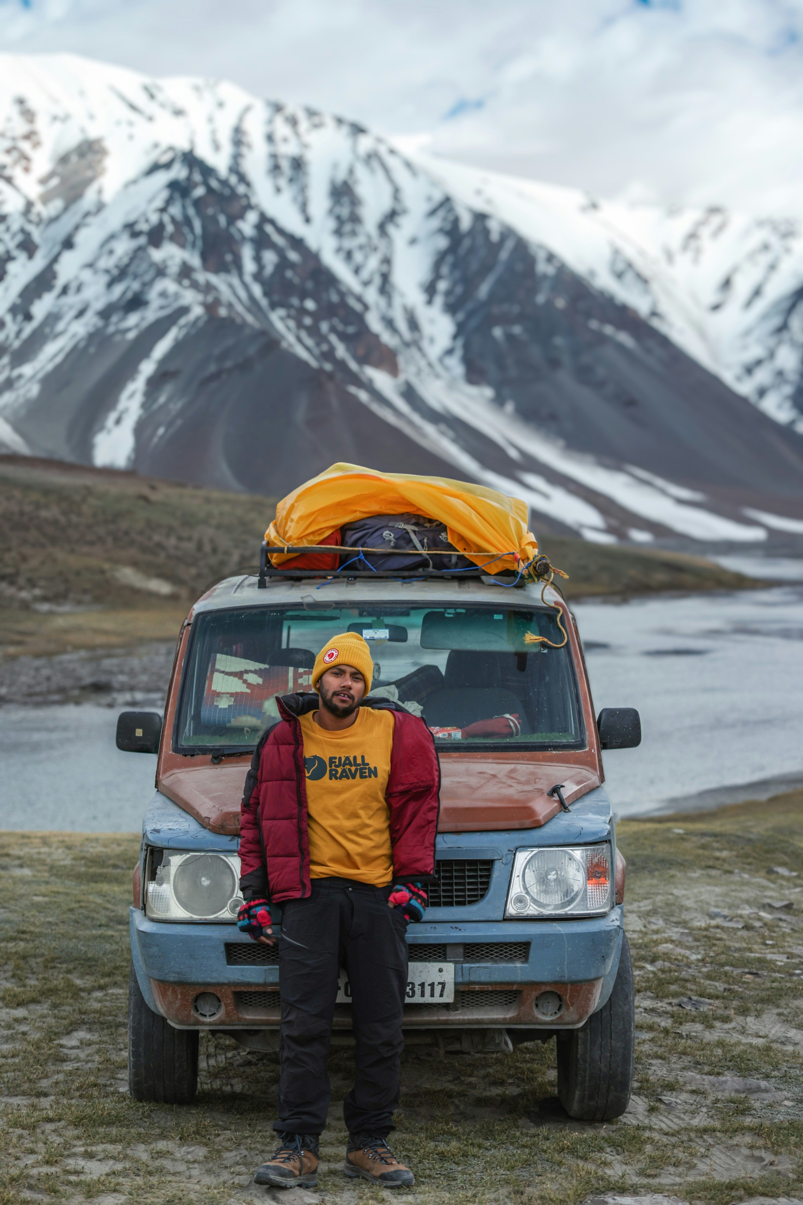 Polar Ridge Patrol: Man and Vehicle at Snow-Capped Backdrop