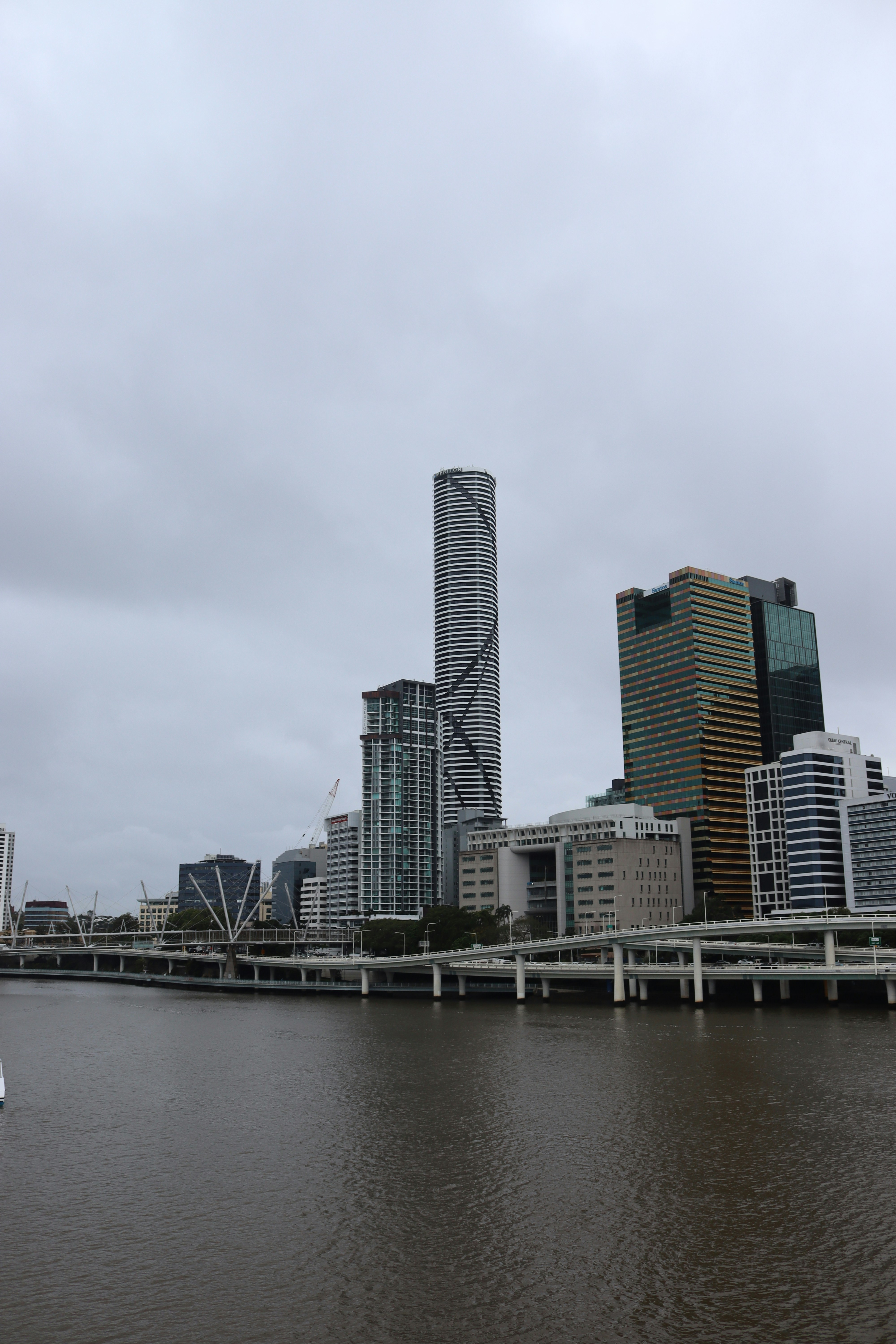 Spiral-Topped Tower Rising Over a Calm Riverfront Skyline