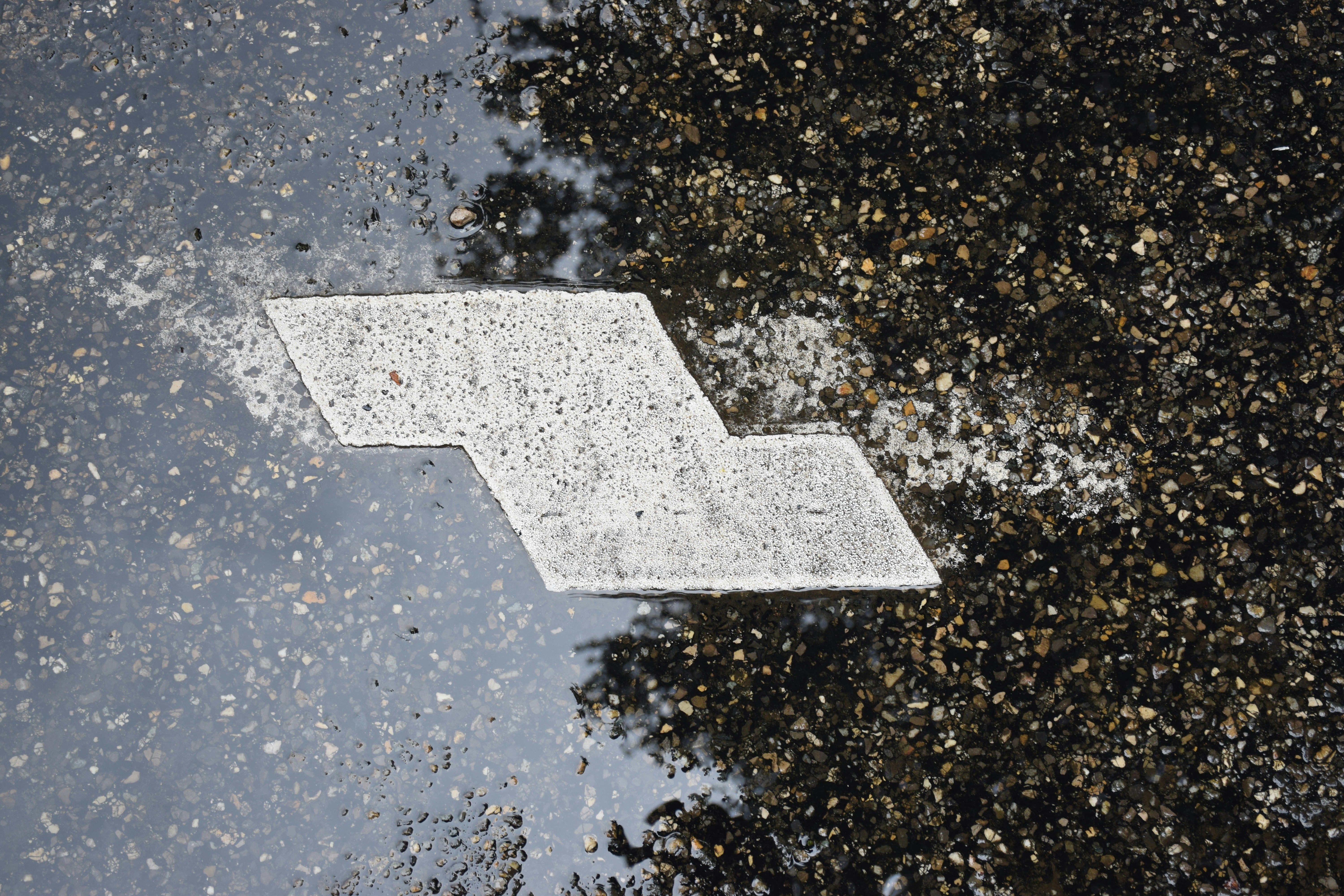 A concrete block sitting on top of a puddle of water photo – Free Road ...