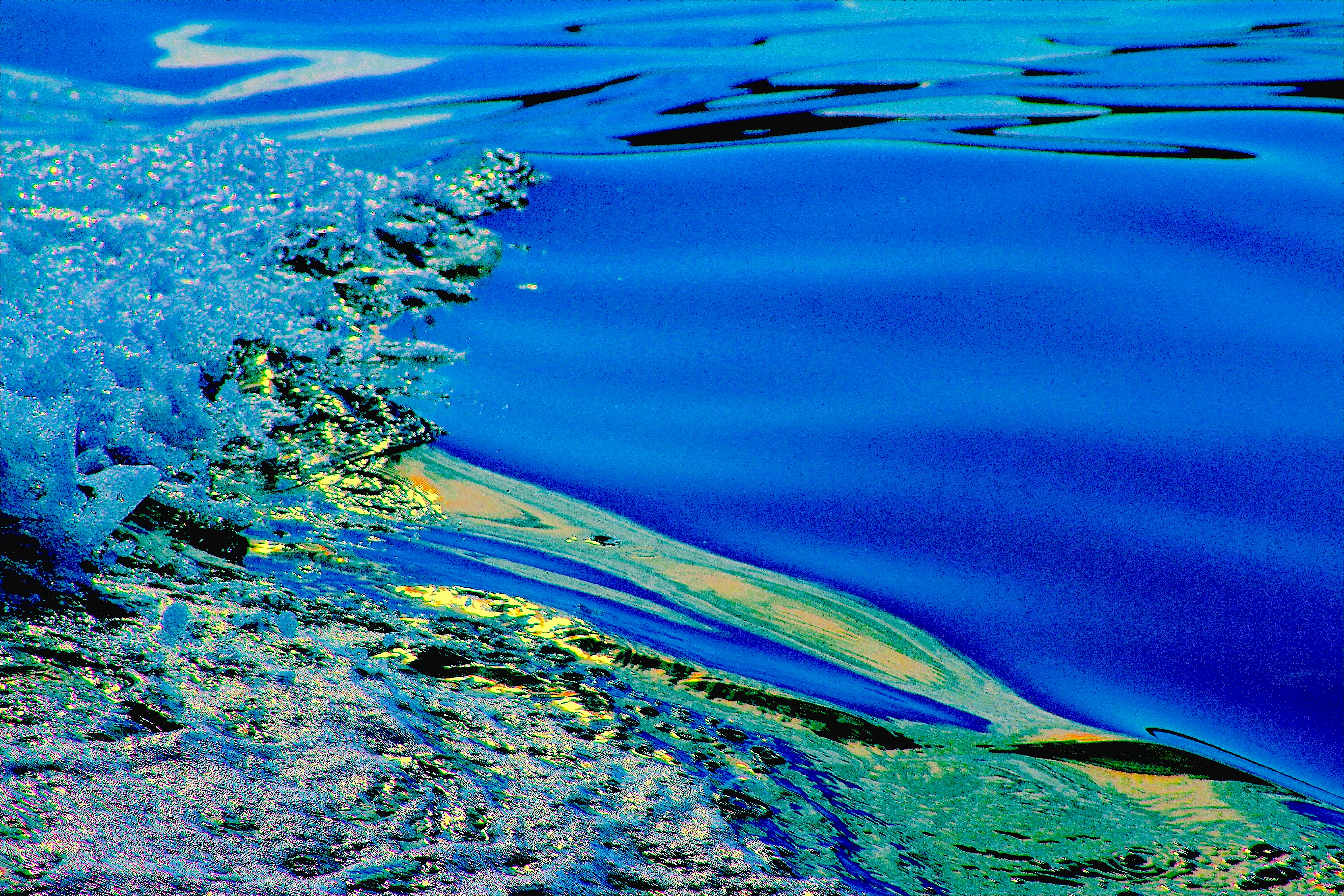 Abstract close-up of flowing water with vivid blue and green hues.