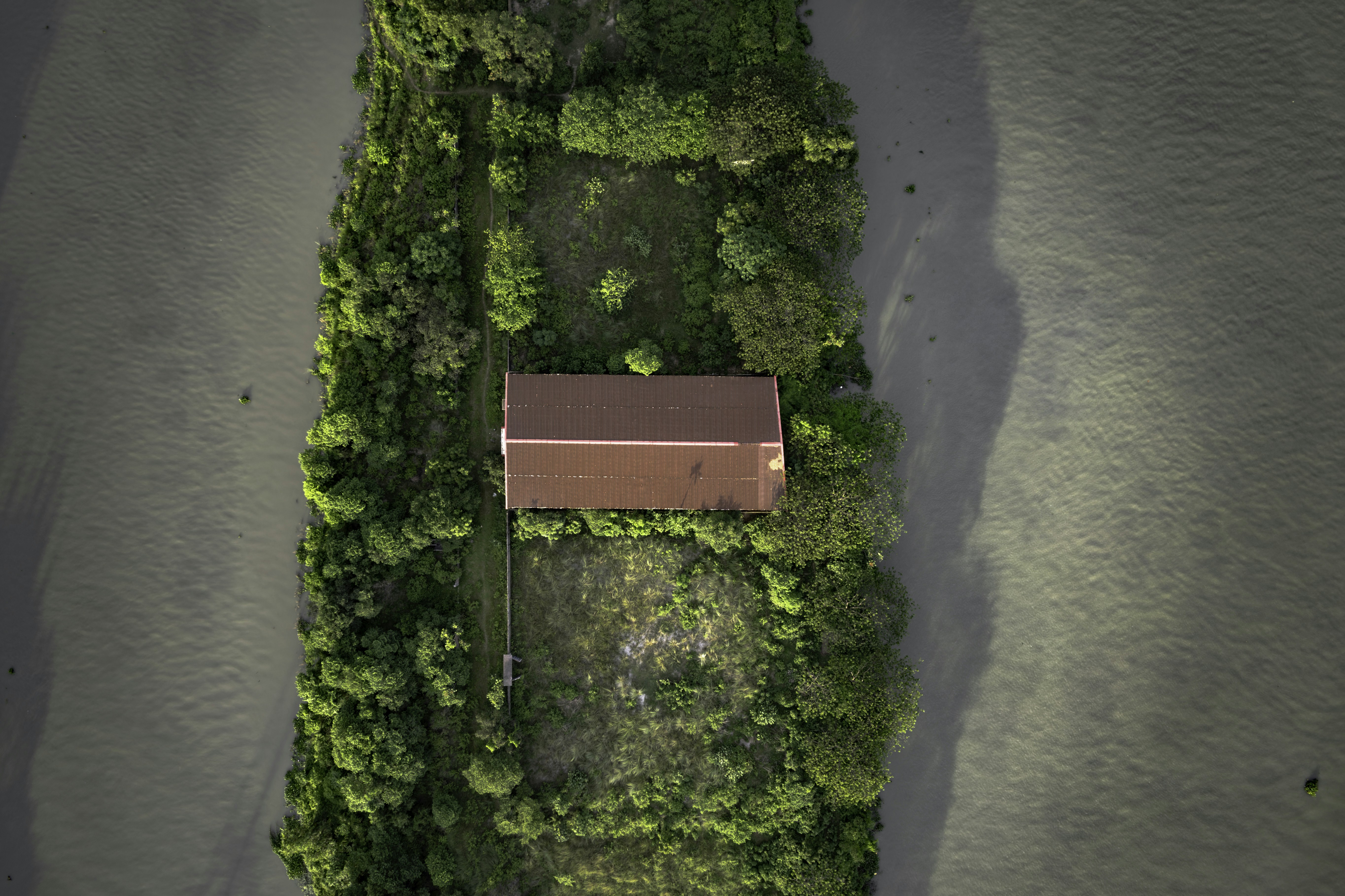 Red Roof on a Narrow Verdant Island Between Quiet Waters