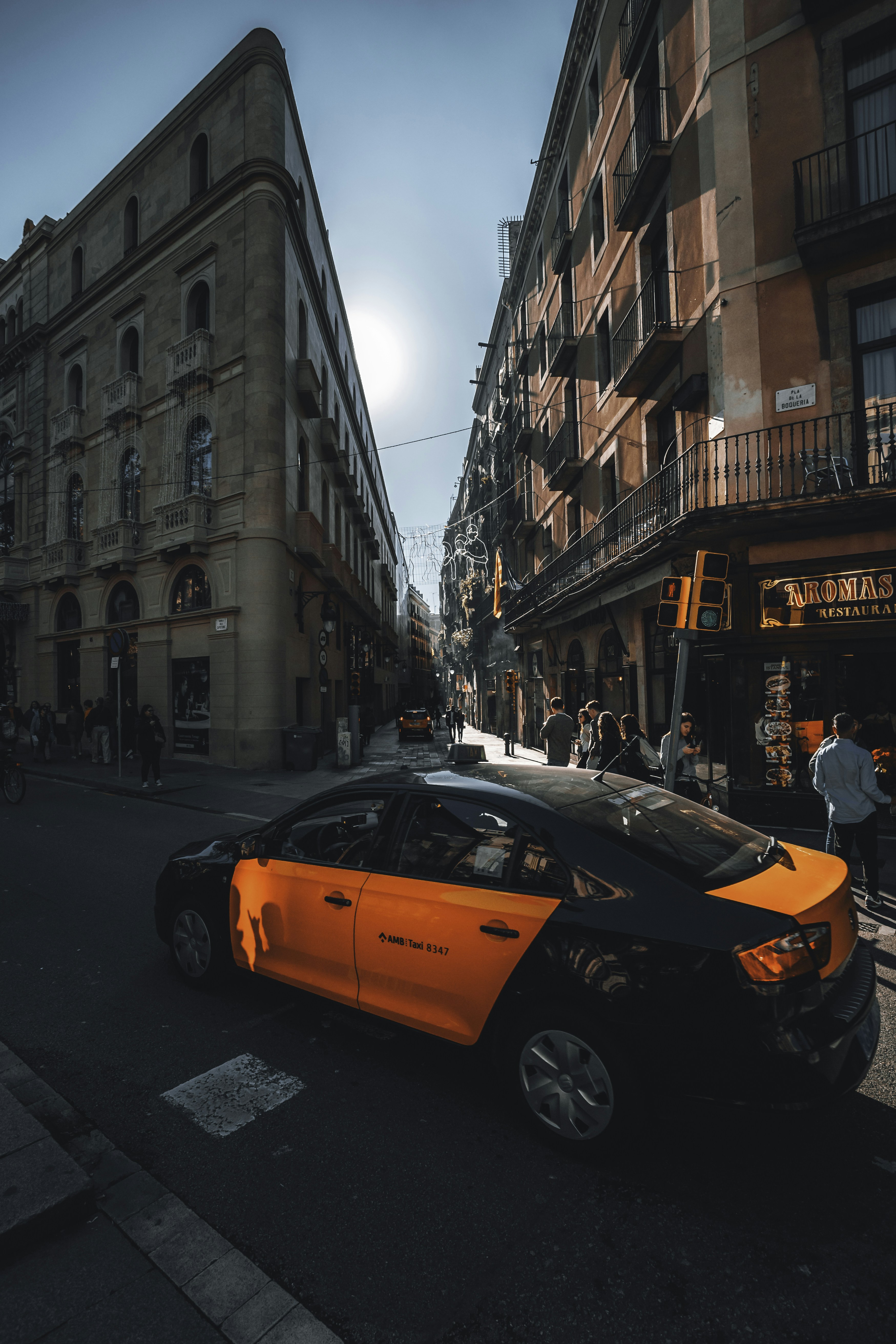 Sunlit Diagonal: A Yellow-Black Taxi Anchors a Shadowed City Street