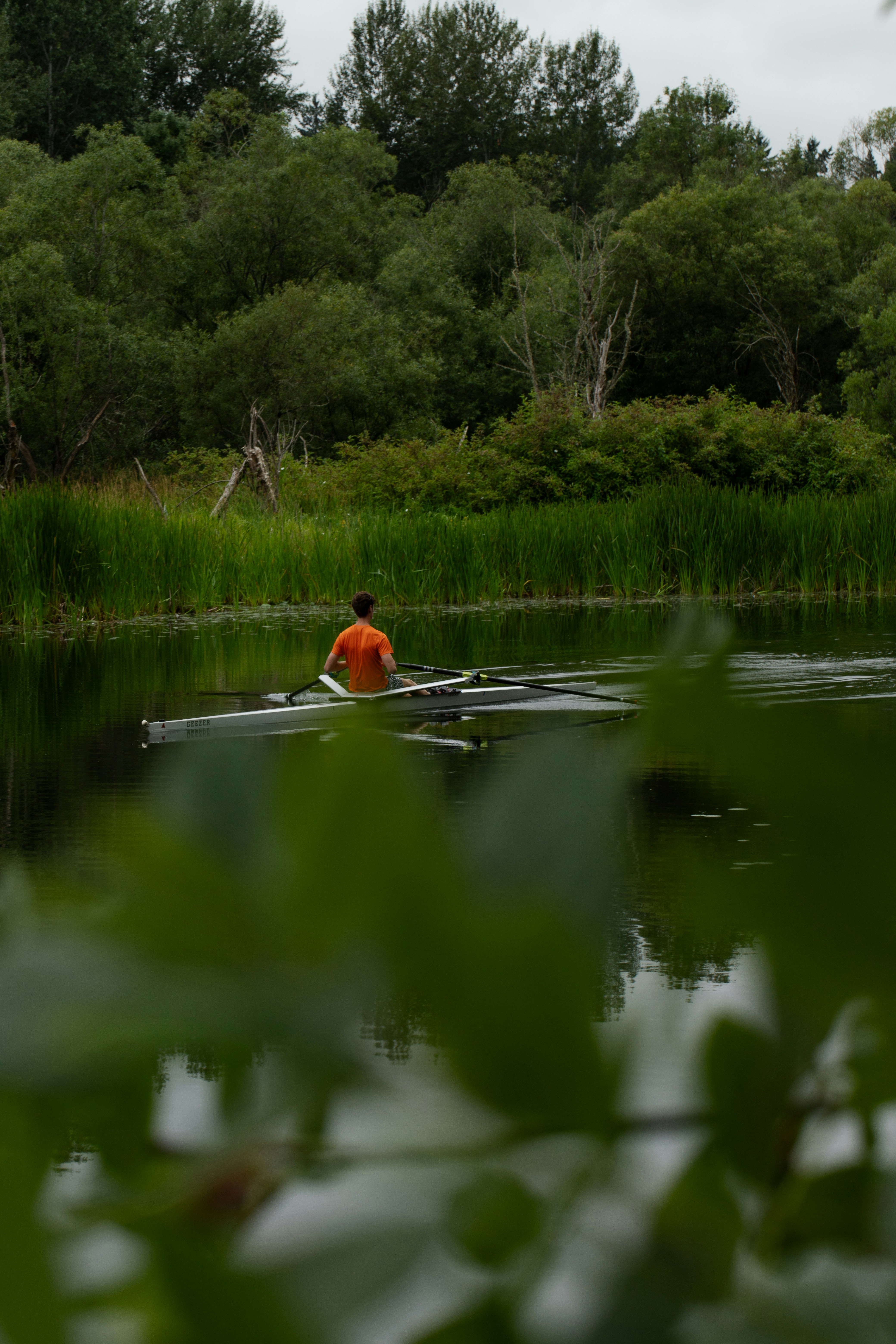 Orange Rowing on a Quiet Emerald River