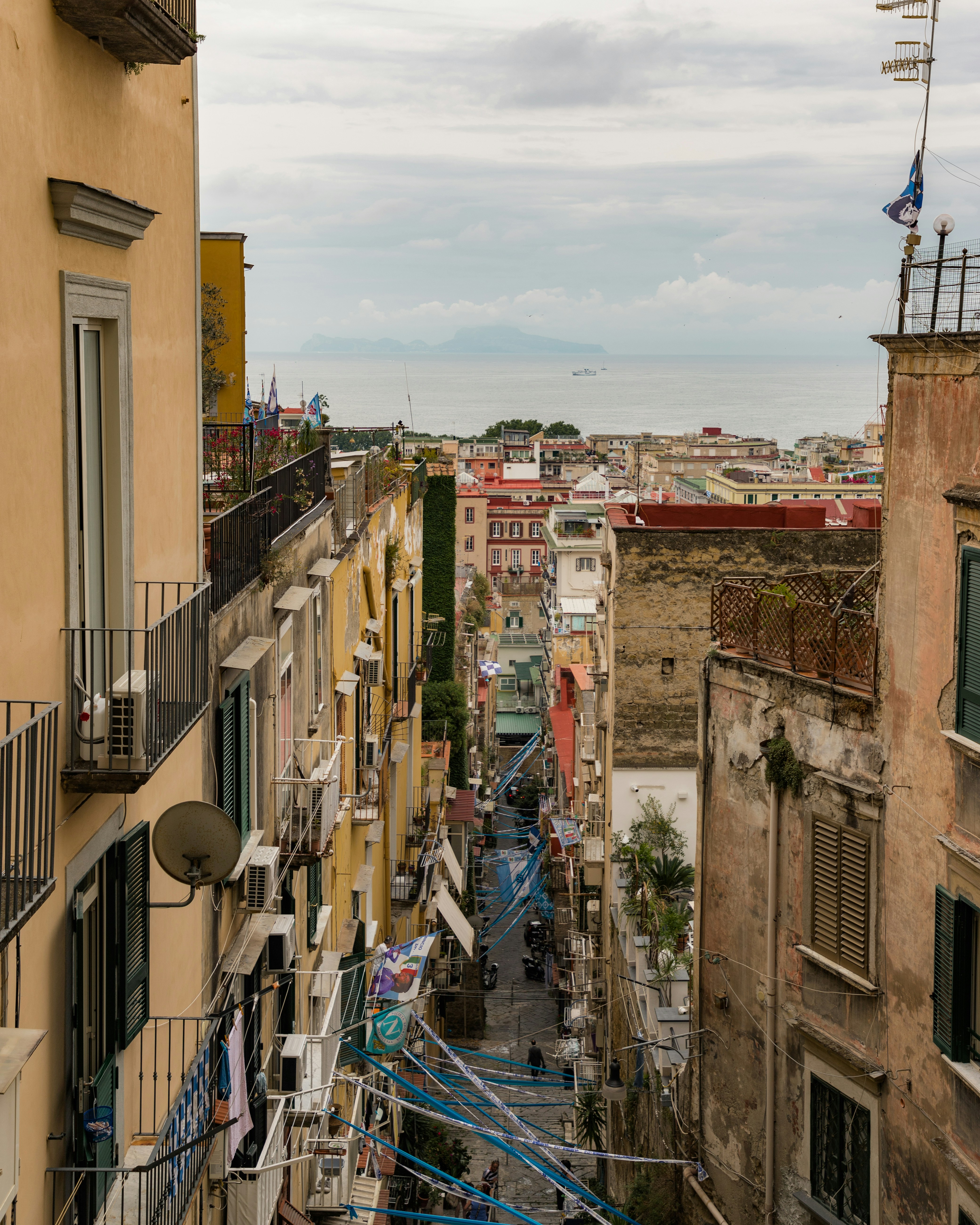 A narrow city street lined with buildings and balconies photo – Free ...