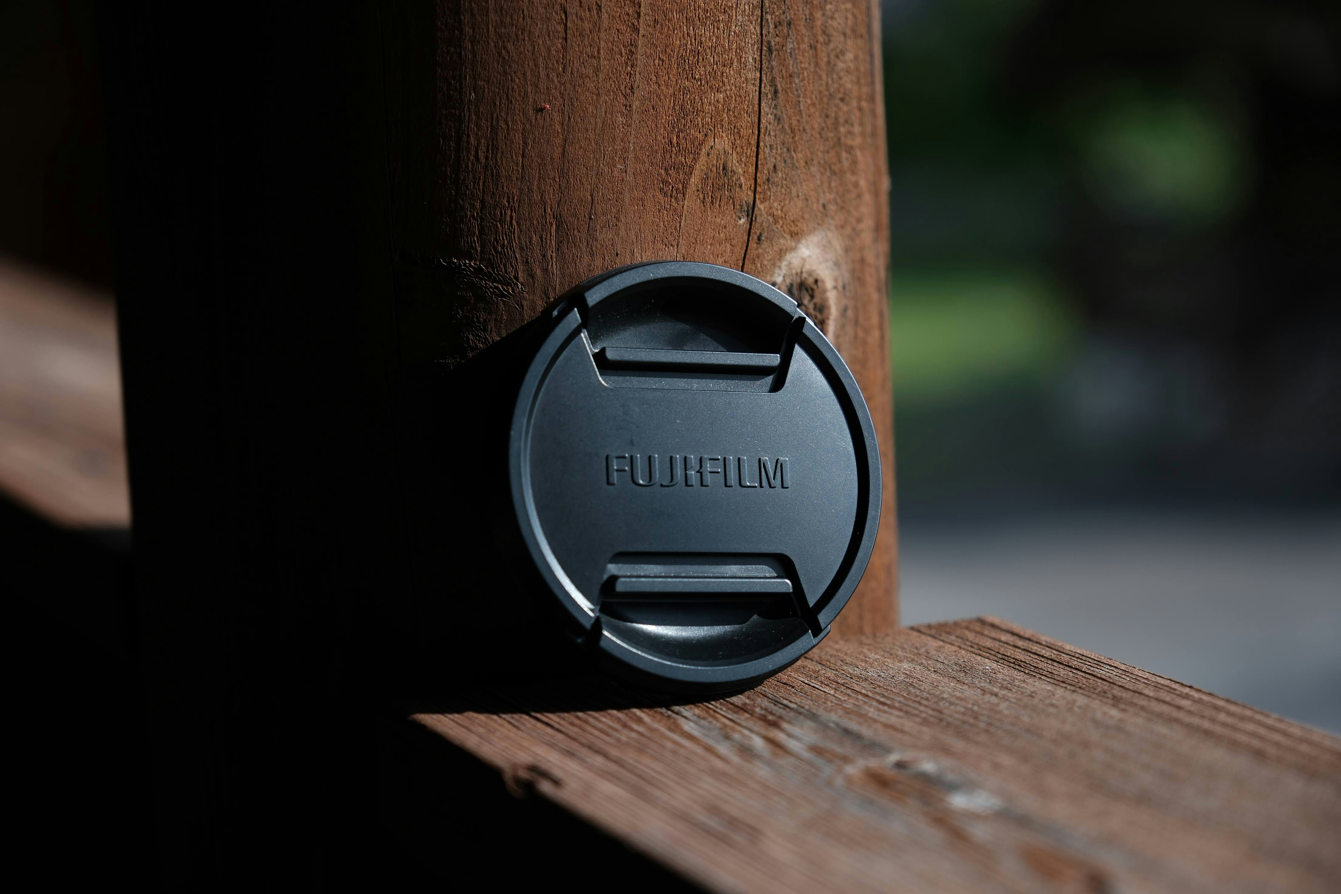 Sunlit Lens Cap on Weathered Wood: A Quiet Macro Moment