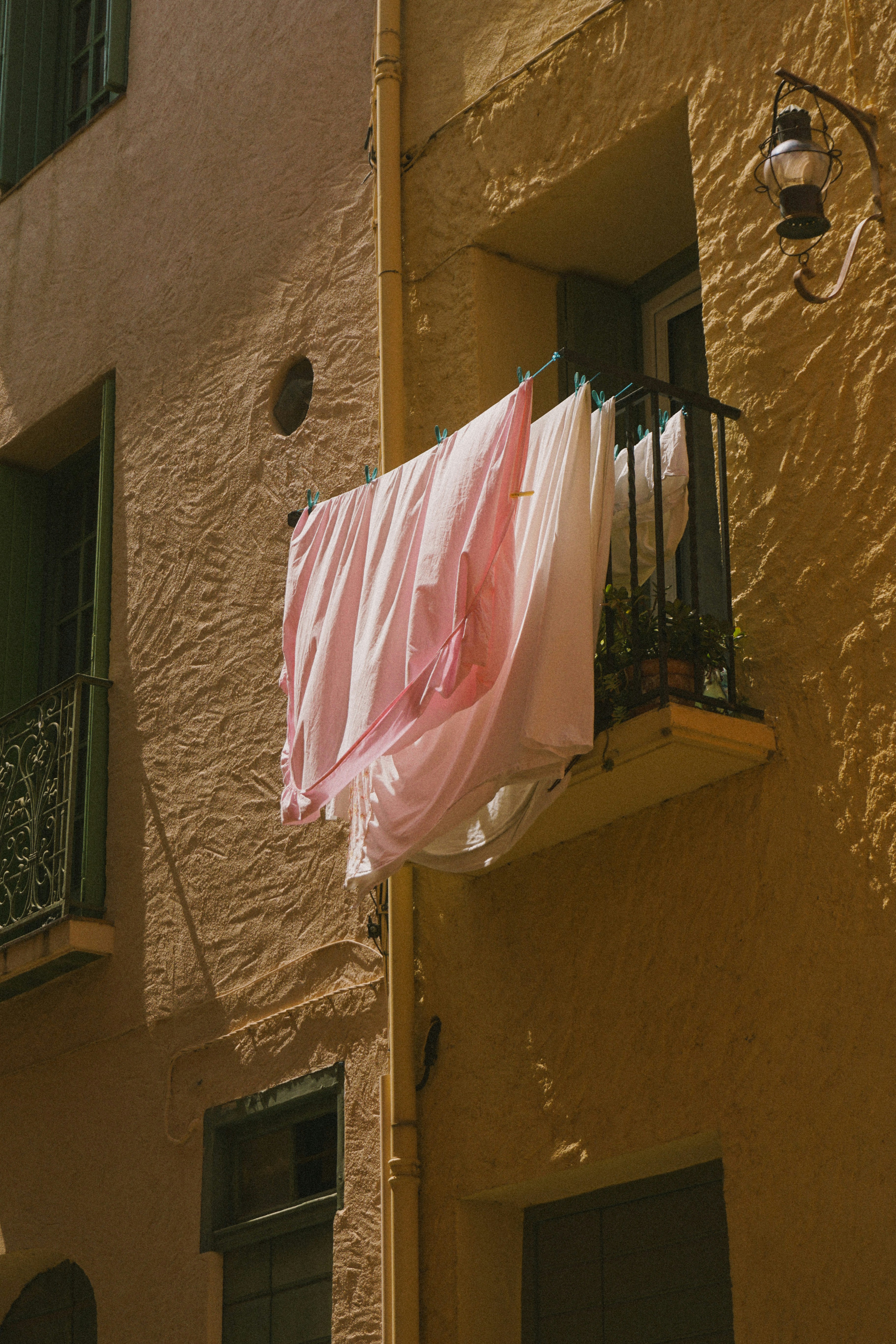 A building with a pink tarp hanging from it's balcony photo – Free ...