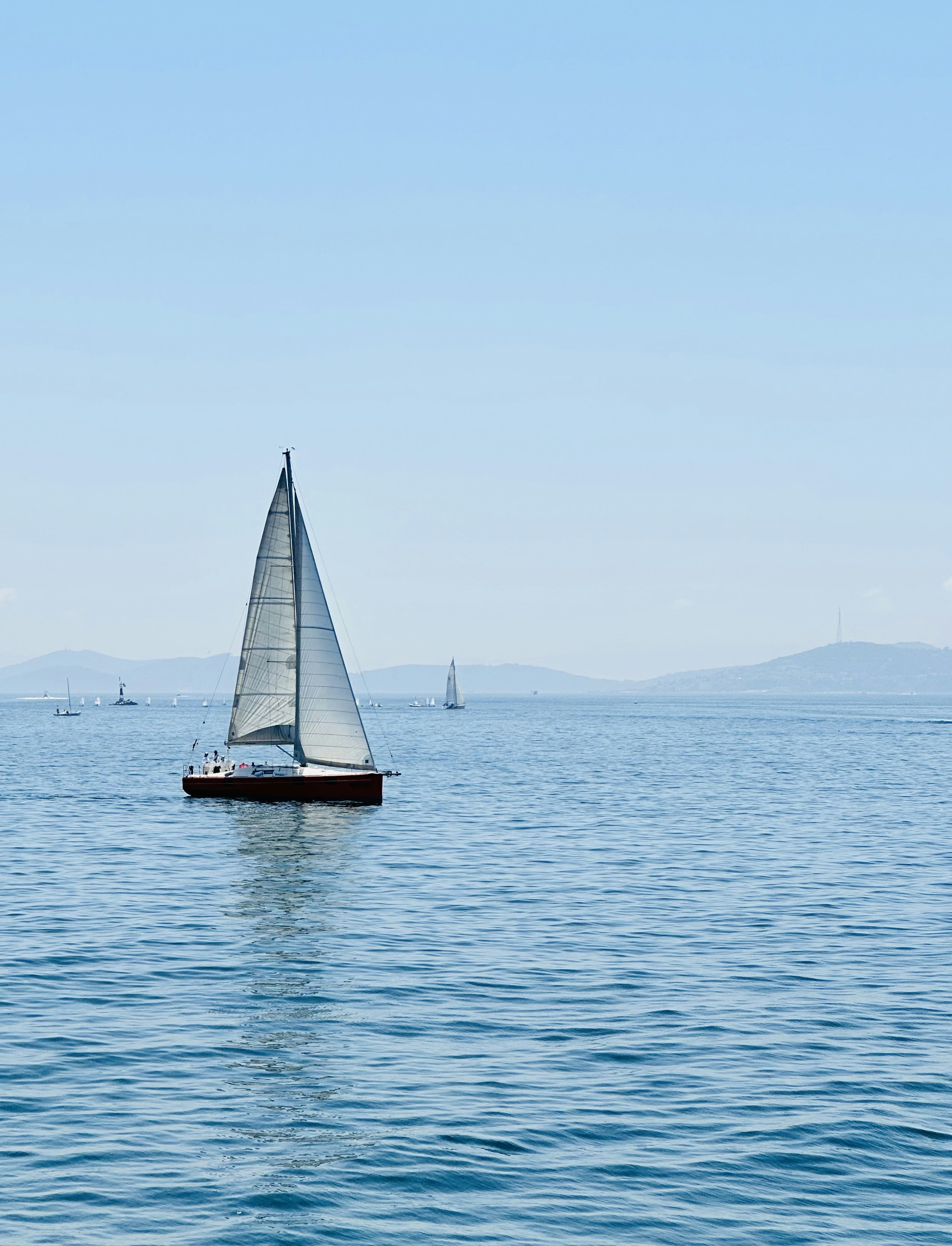 A sailboat floating in the middle of a large body of water photo – Free ...