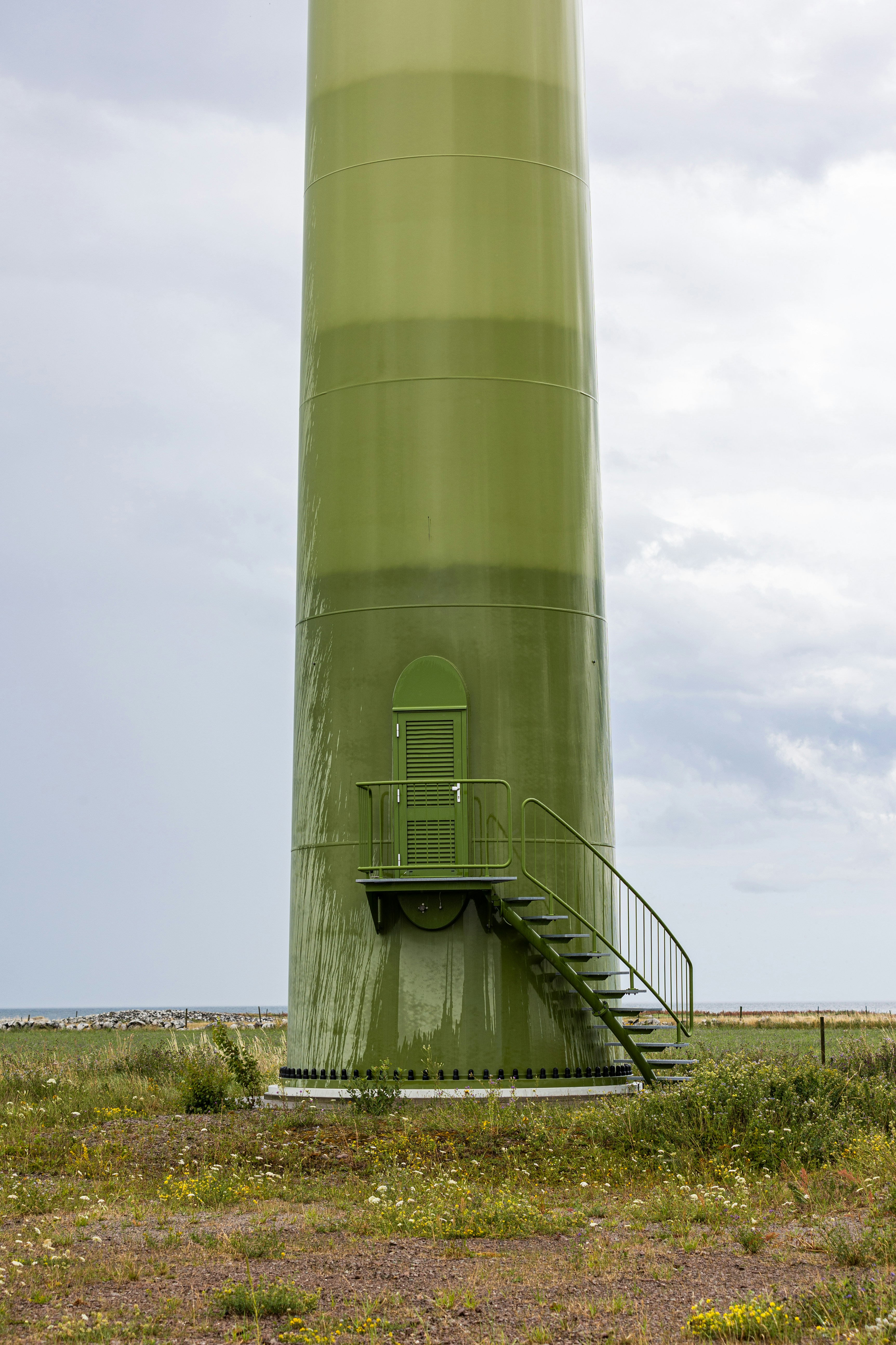 Verdant Cylindrical Sentinel with a Staircase by the Sea