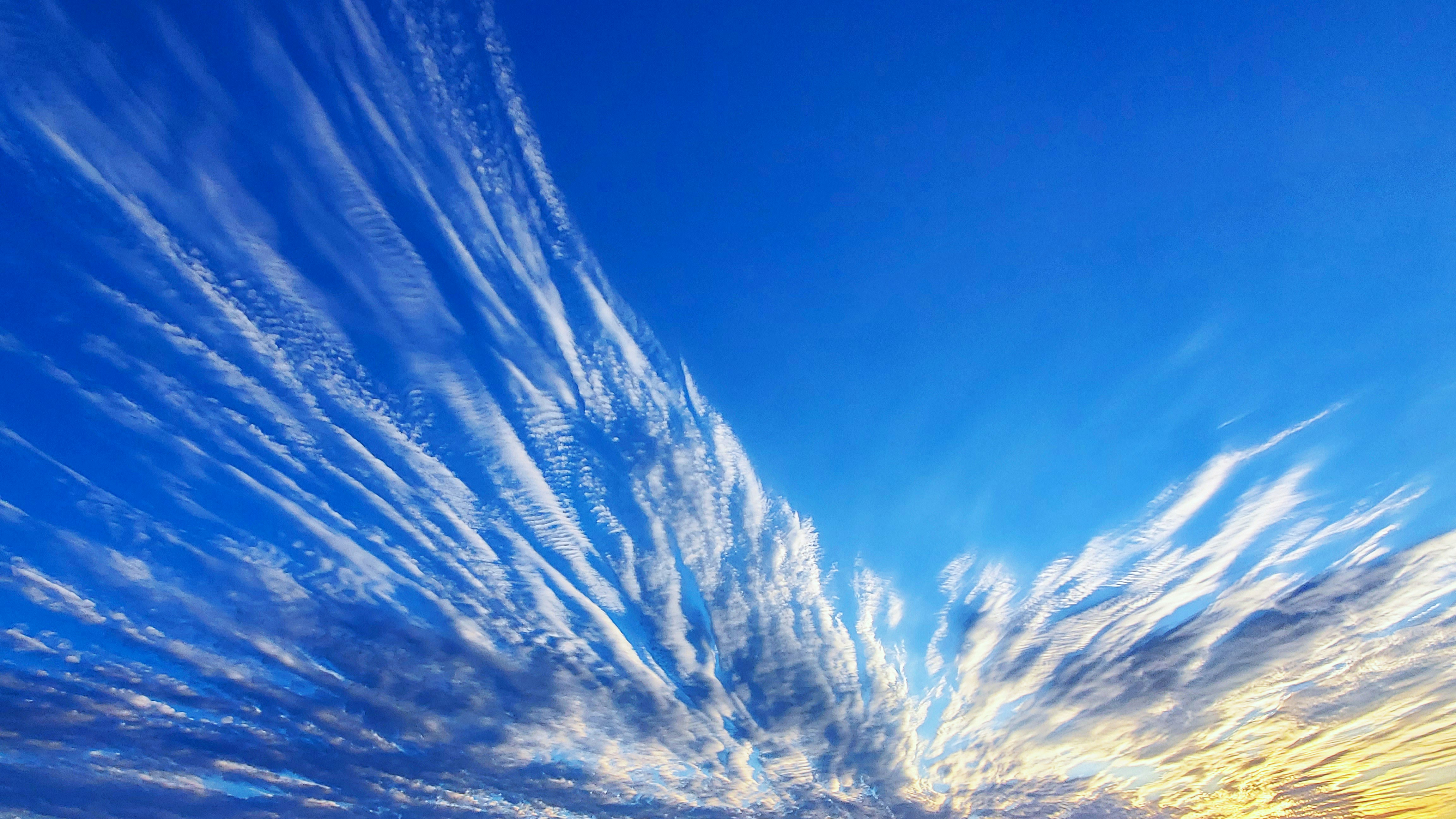 Radiant Convergence: Contrails Fanning Across a Cerulean Dawn
