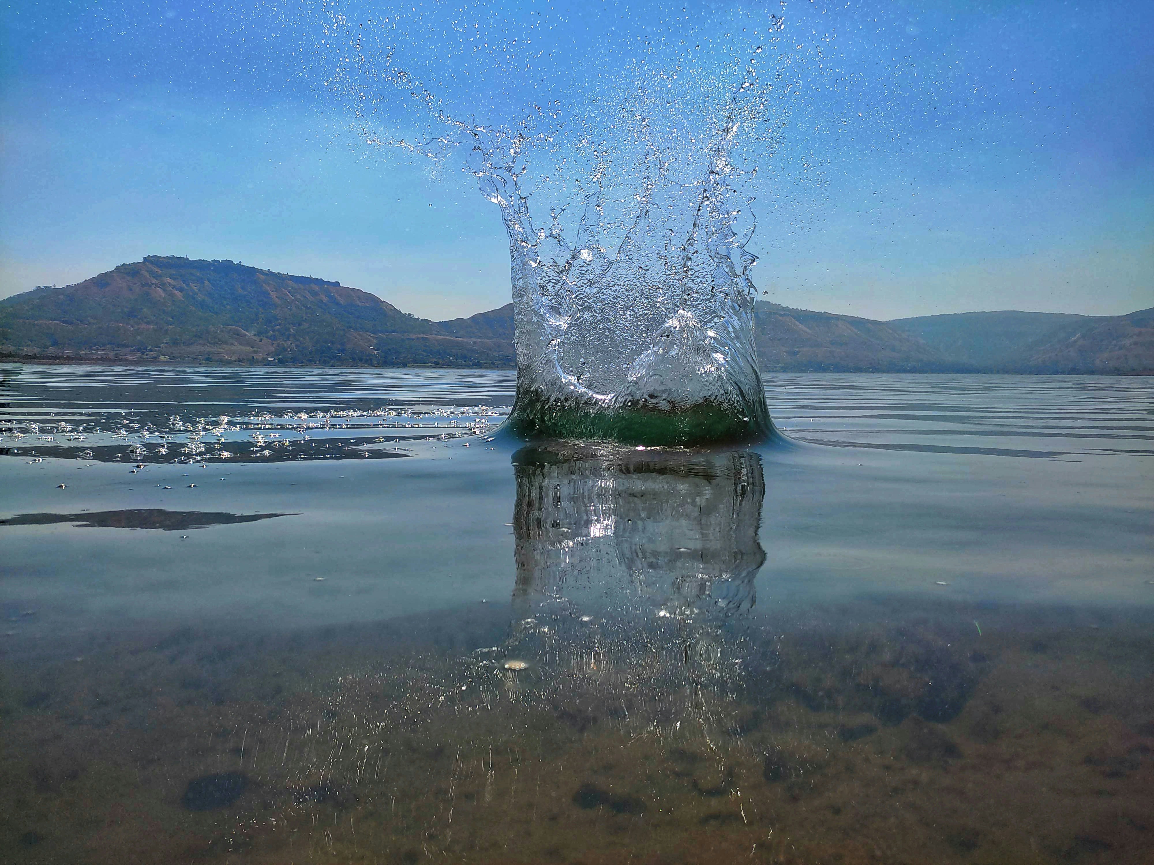 A large splash of water on top of a body of water photo – Free Splash ...