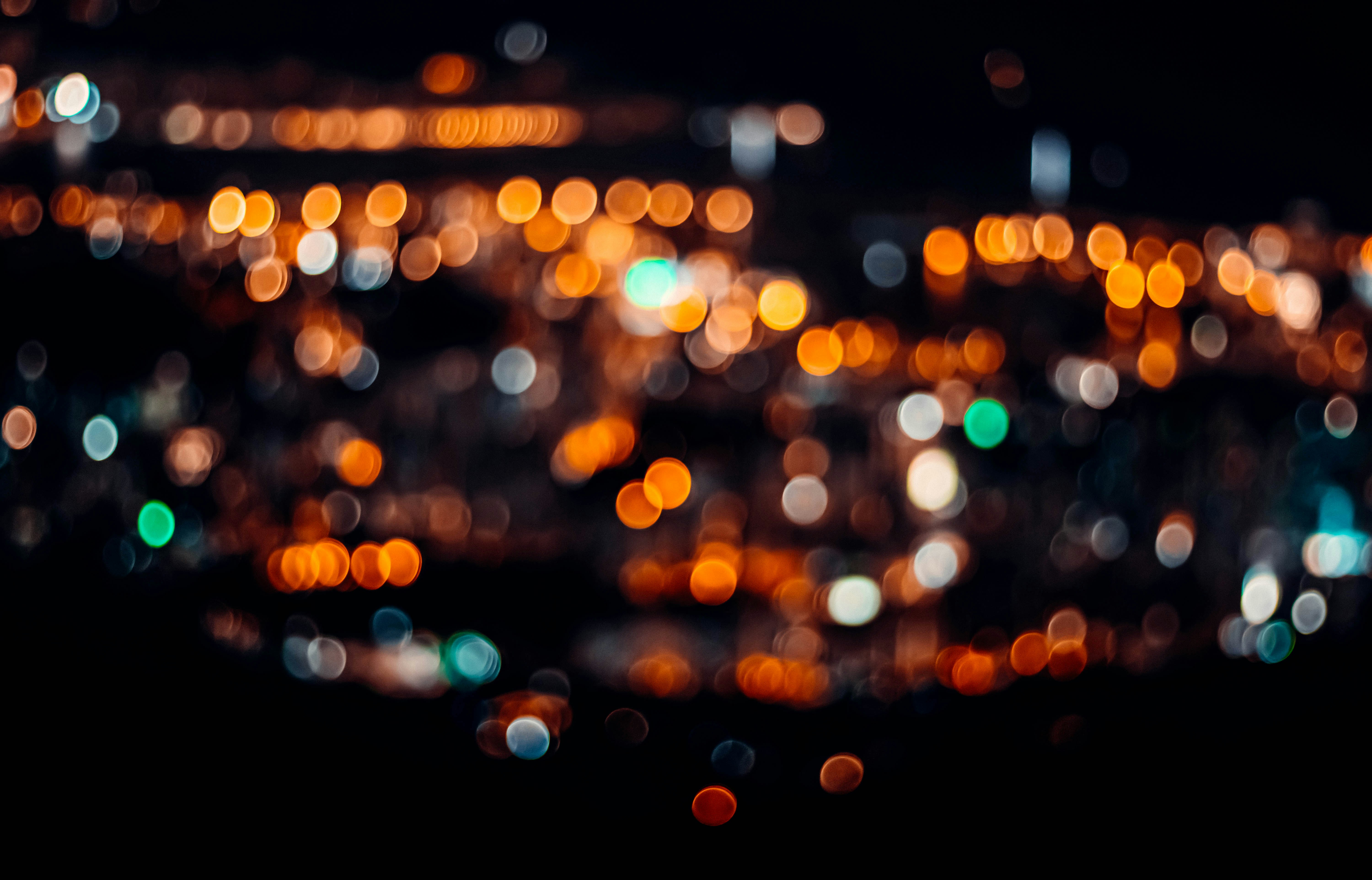 Blurred urban lights create a vibrant bokeh pattern against a dark backdrop.