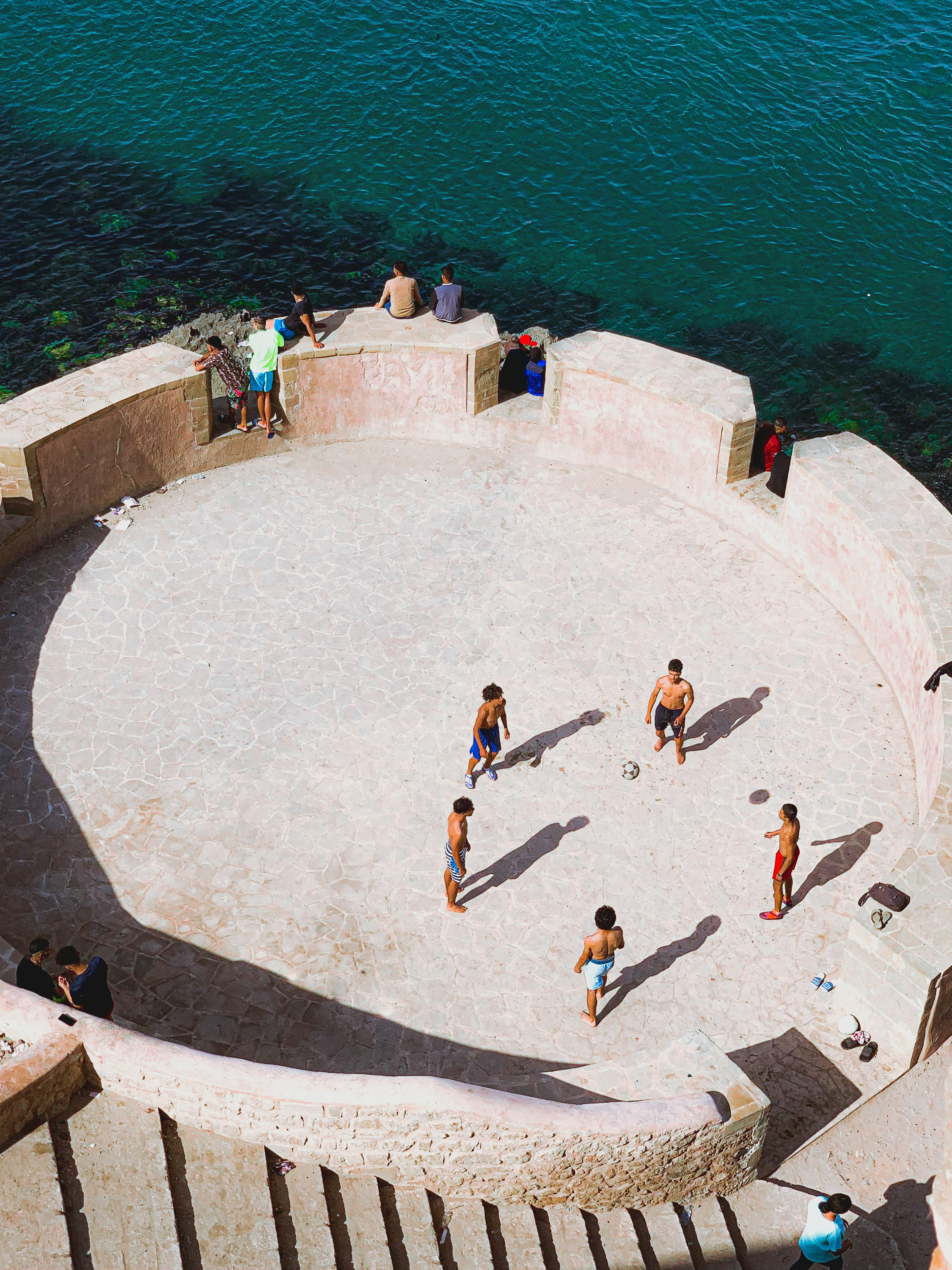 A group of people standing on top of a cement wall photo – Free People ...