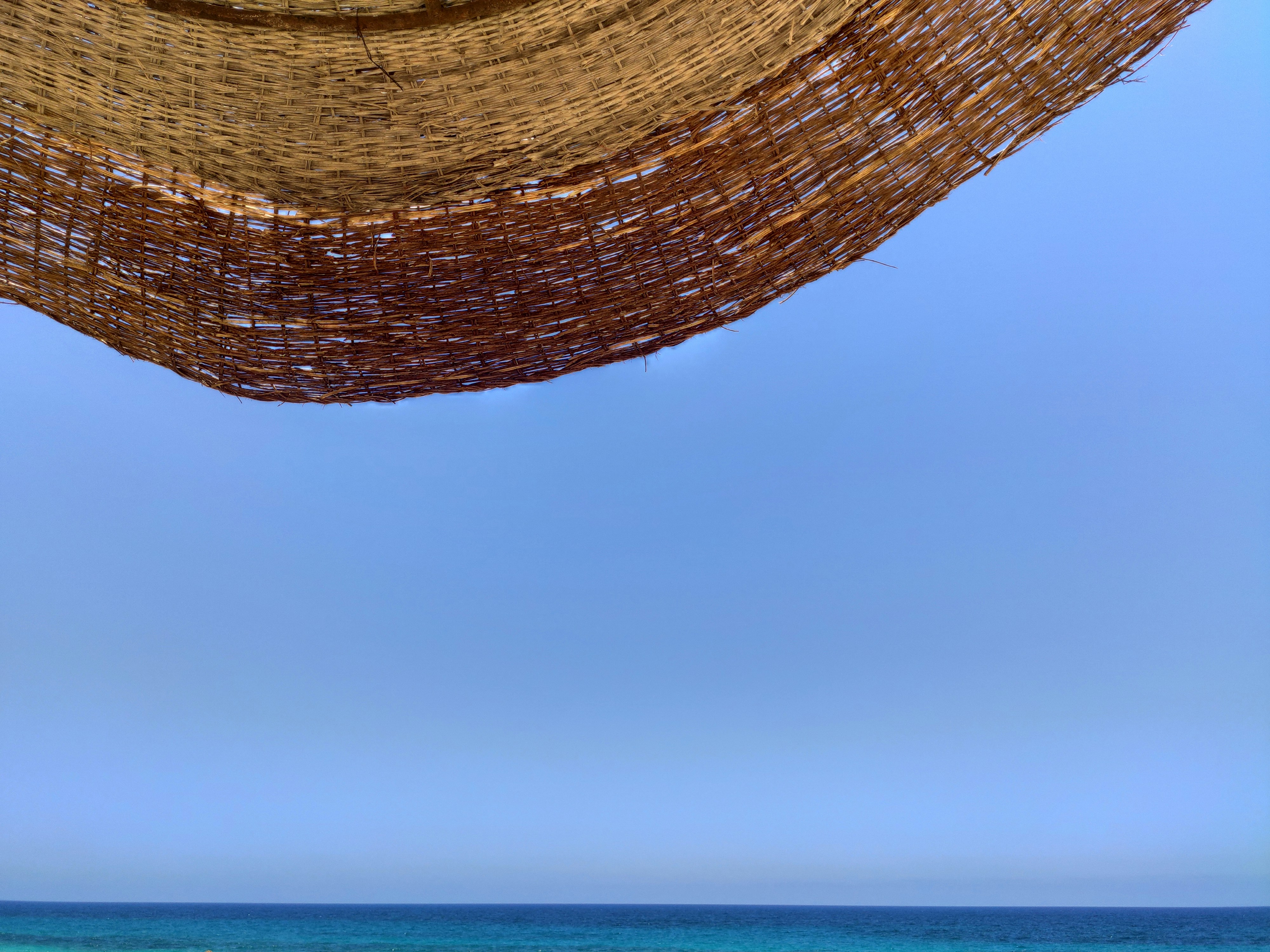 Woven Shade Above the Sea: A Minimal Coastal Moment