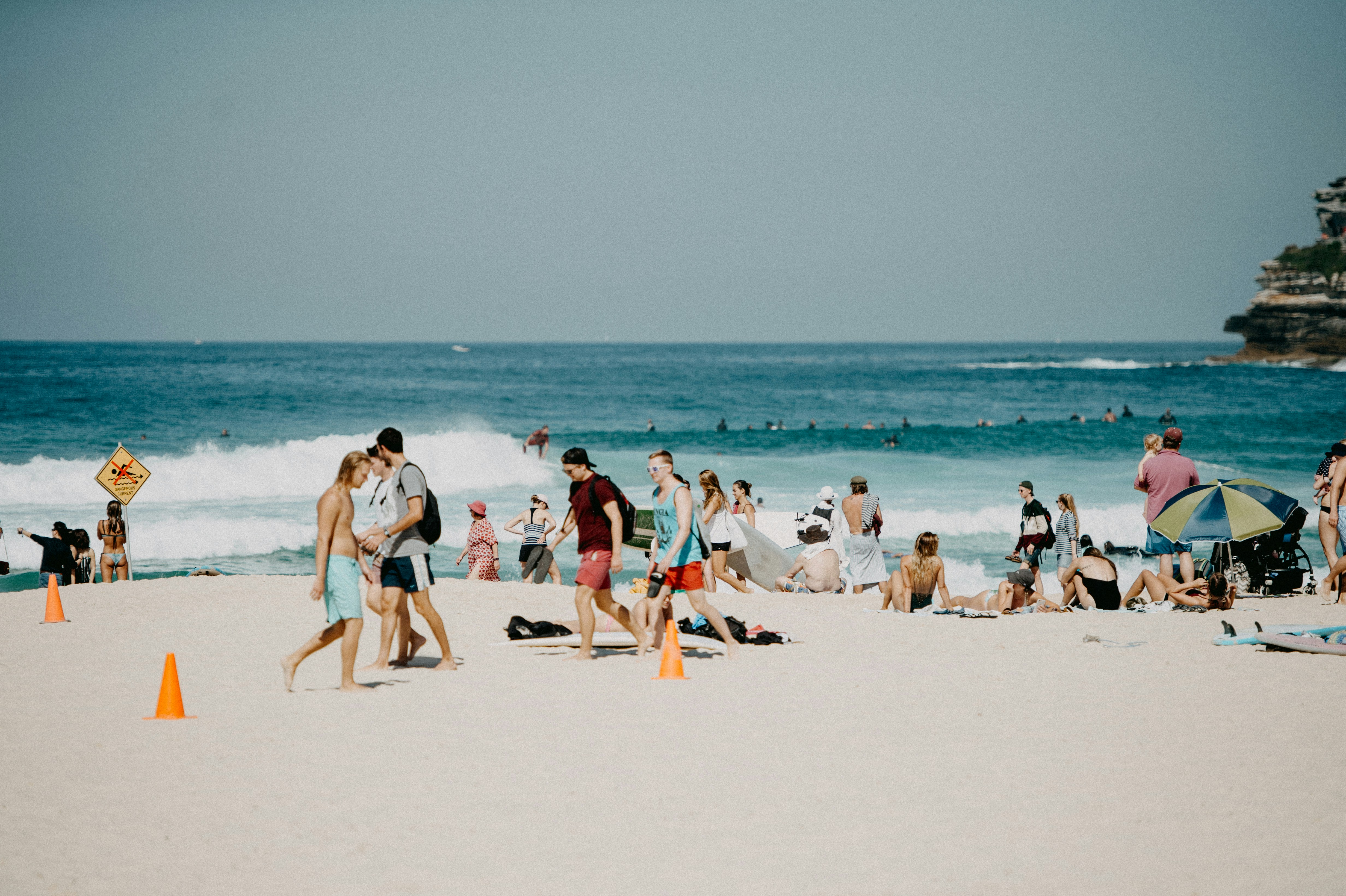 A group of people walking on a beach next to the ocean photo – Free ...