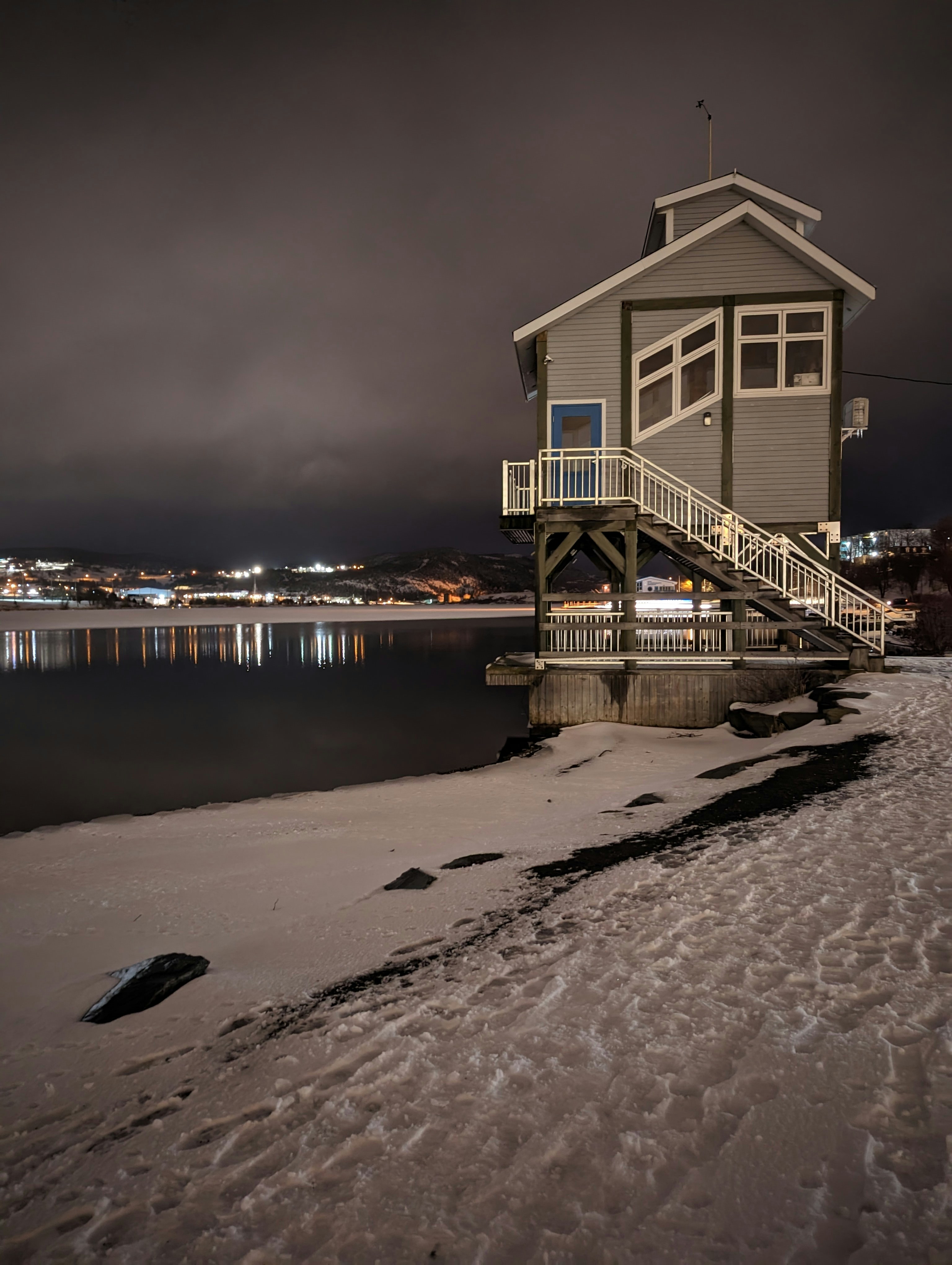 Staircase to the Quiet Bay: A Snowbound Cabin Over Water at Night