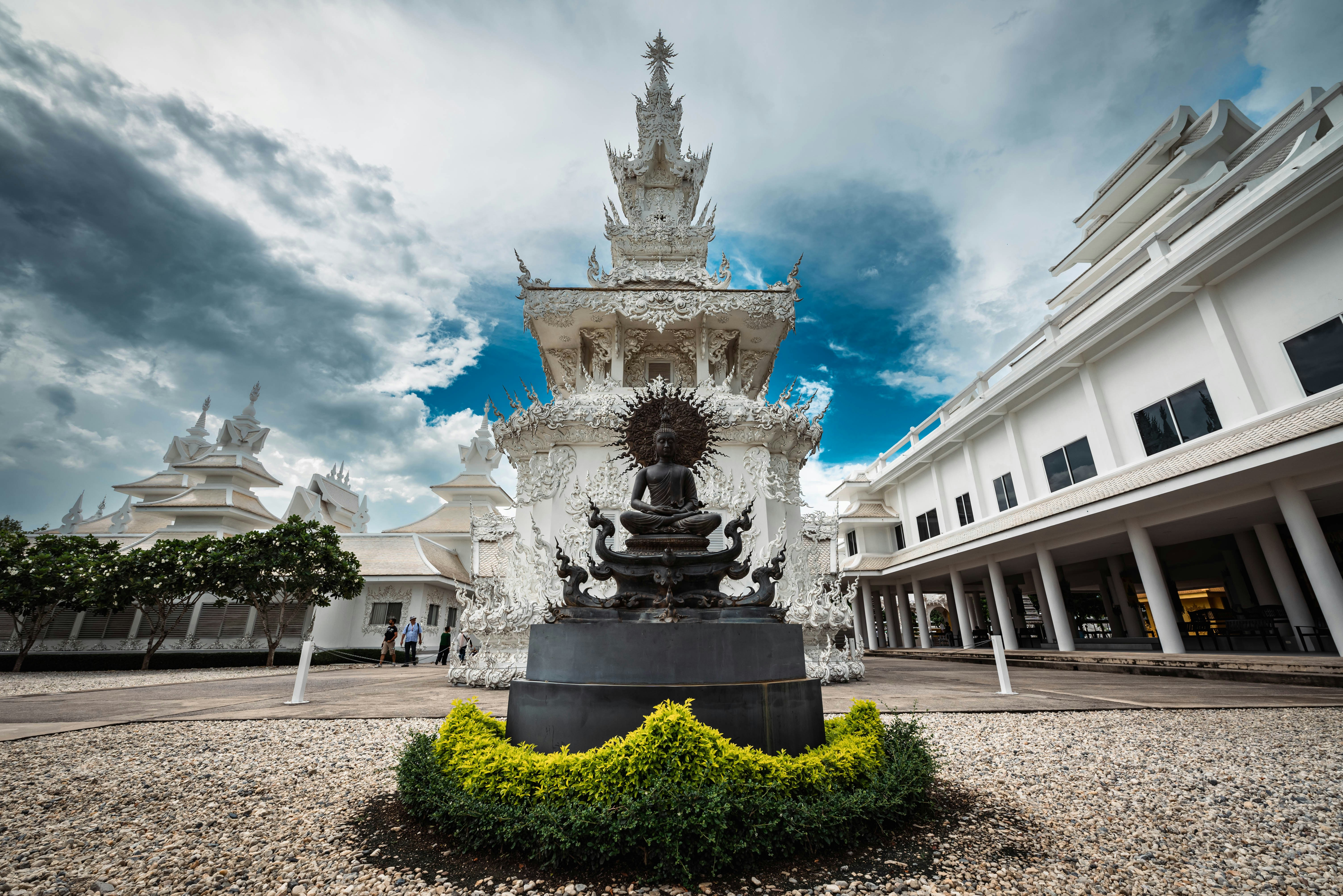 a fountain in a courtyard with a clock tower in the background