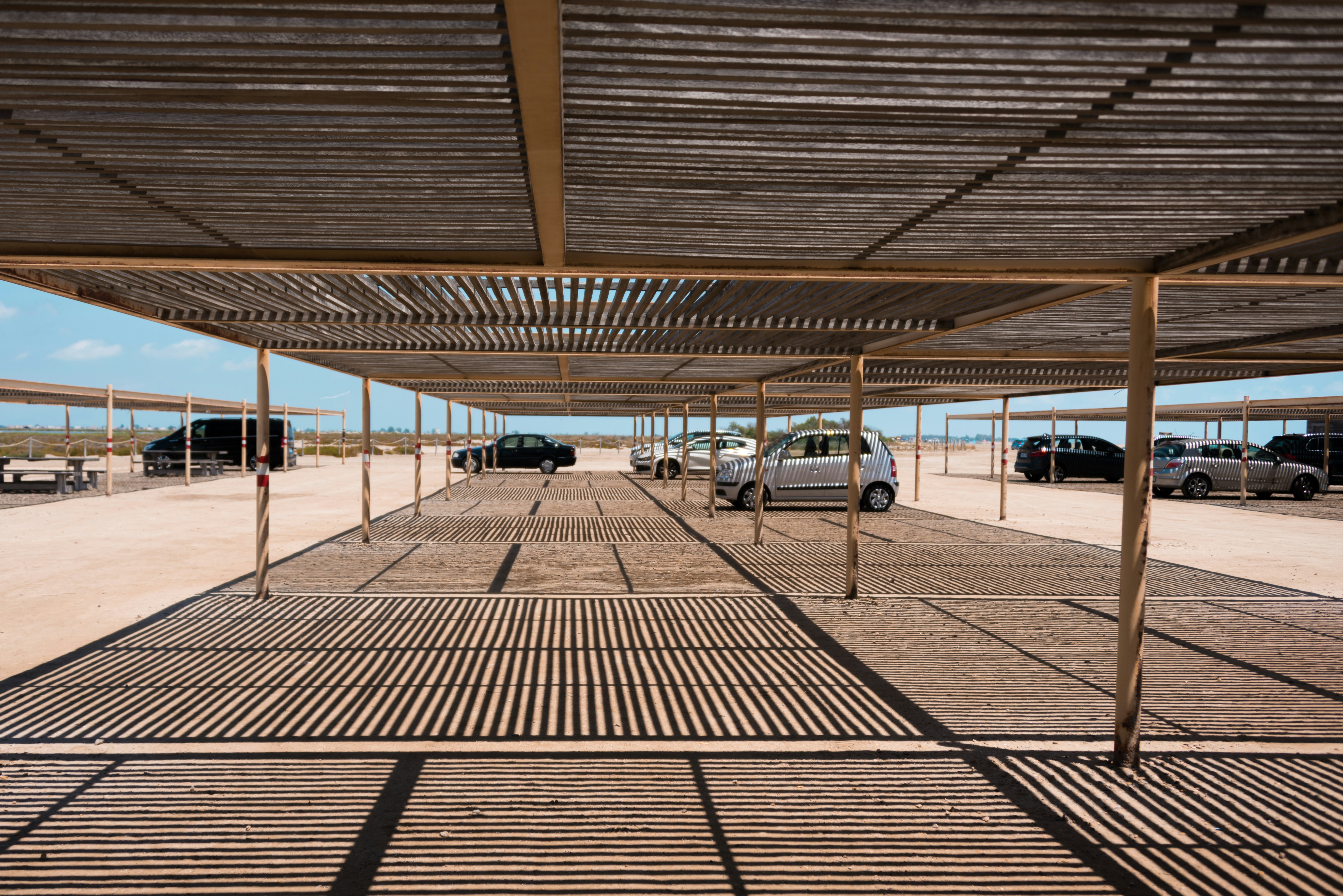 Vanishing Lines Under a Pergola: A Parking-Lot Corridor to the Sea