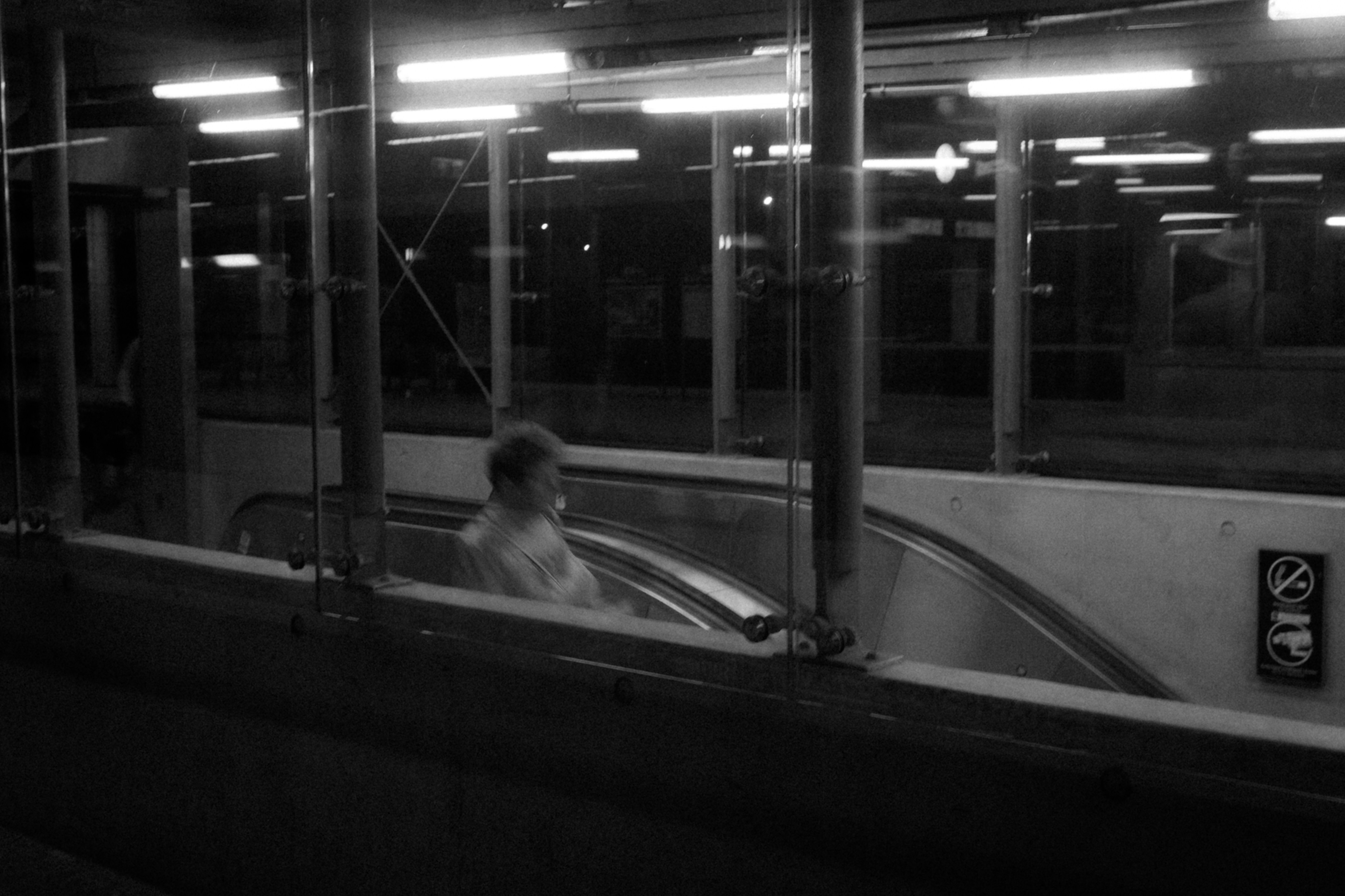 Dim Escalator, Moving Silence: A Subway Rider in Monochrome