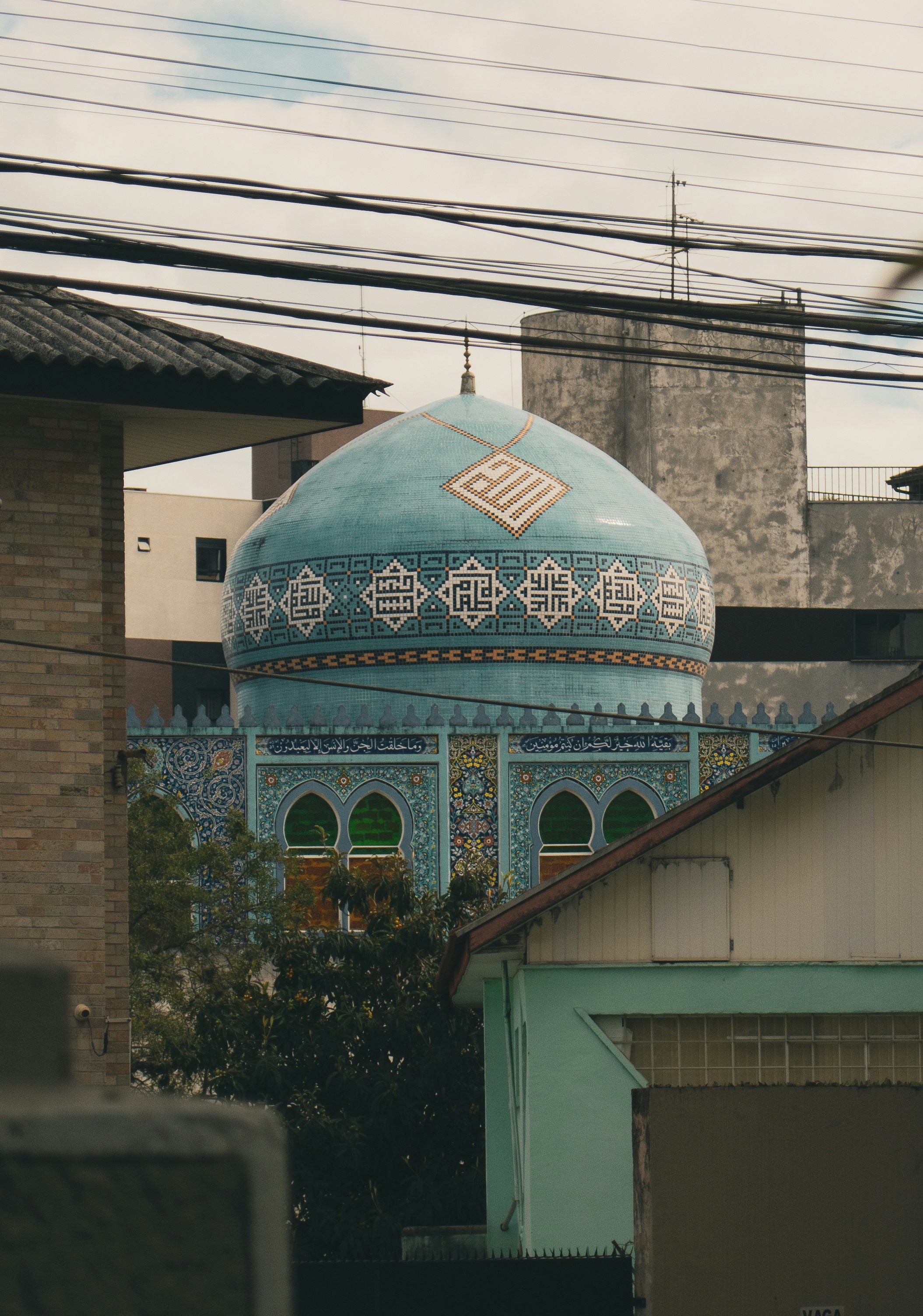 Blue Dome Amid Concrete: A Mosque Crowned by a Narrow City Gap