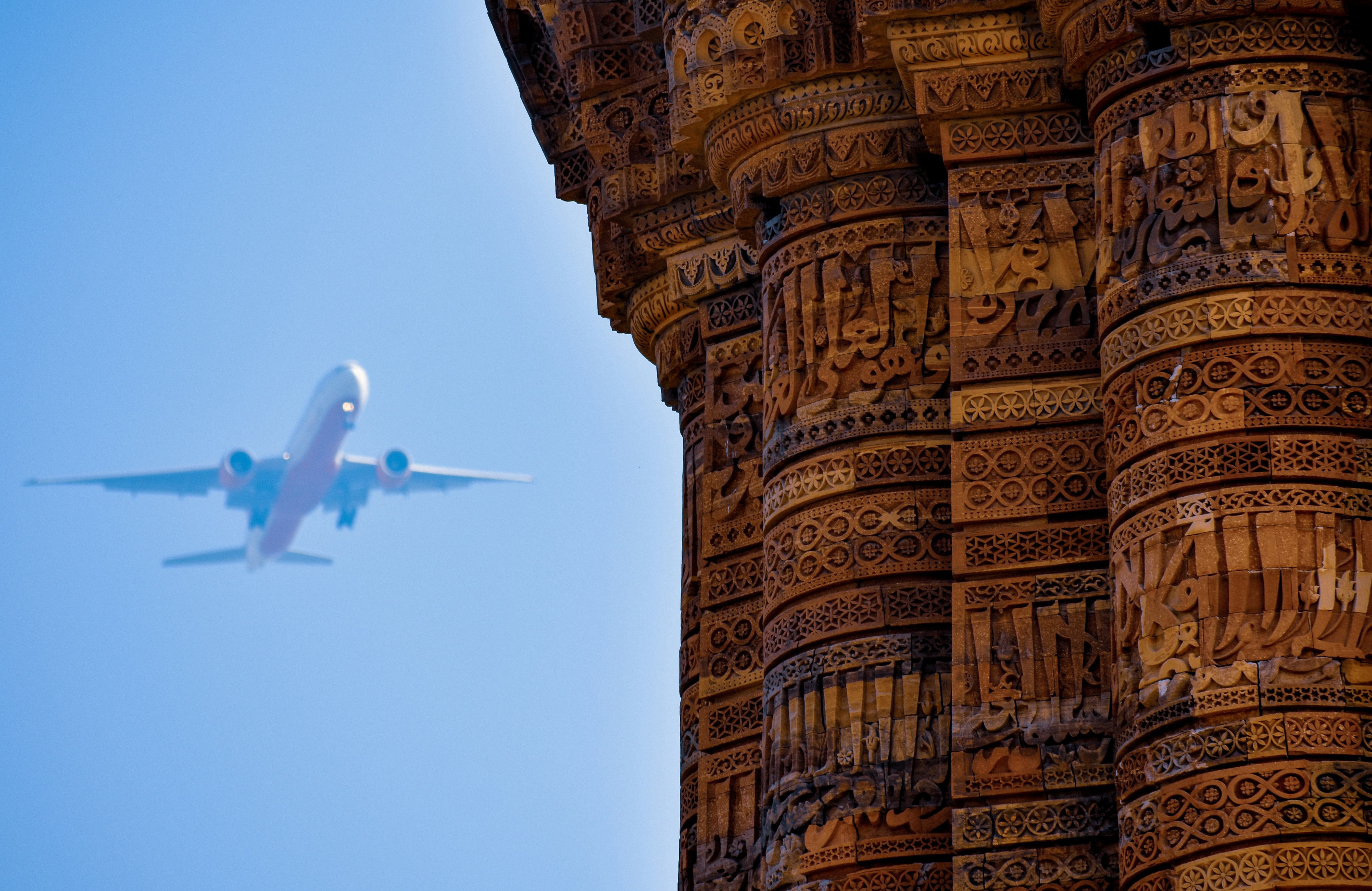 Ancient Carvings Framed by a Distant Skyward Flight