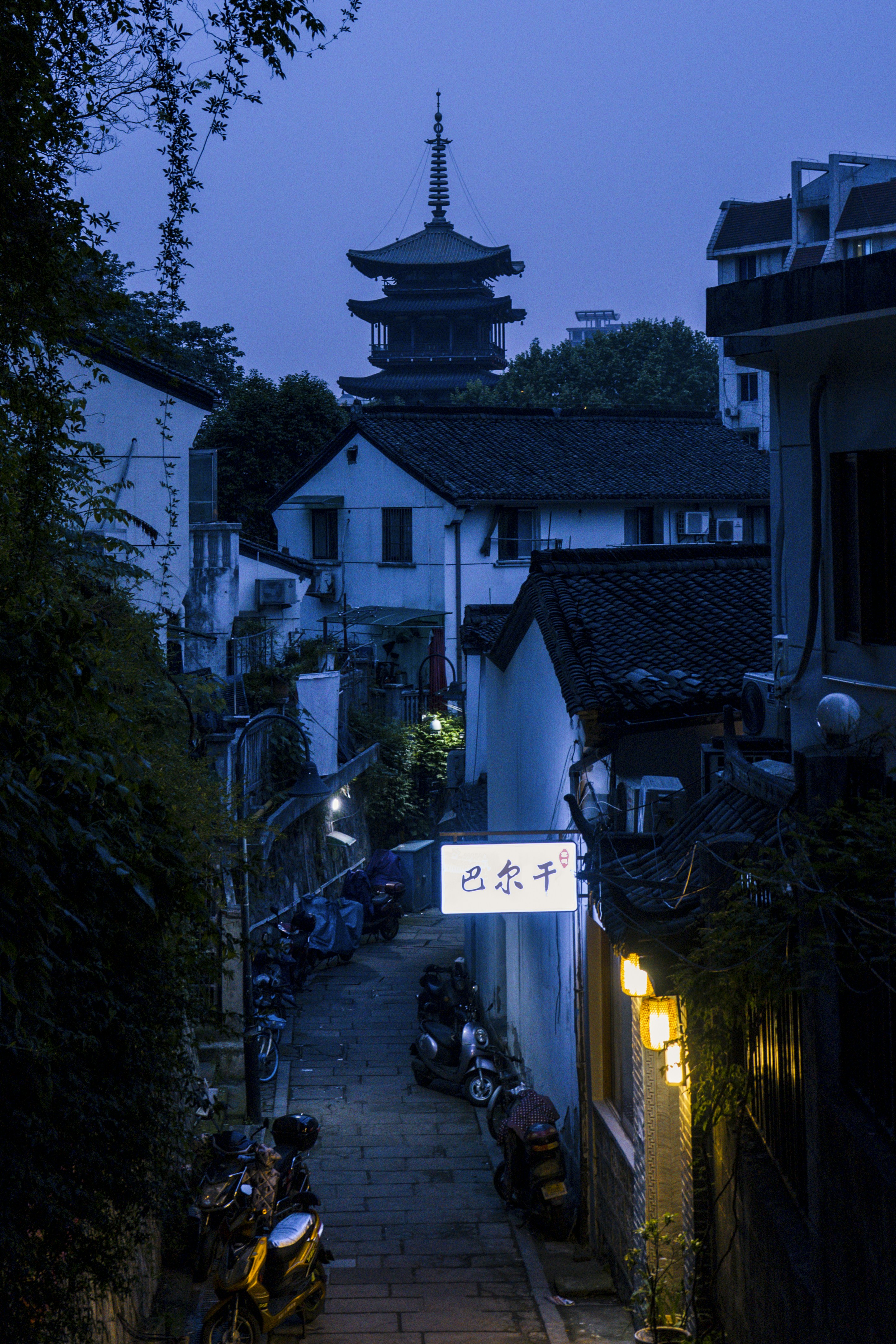 a narrow street with a sign on the side of it