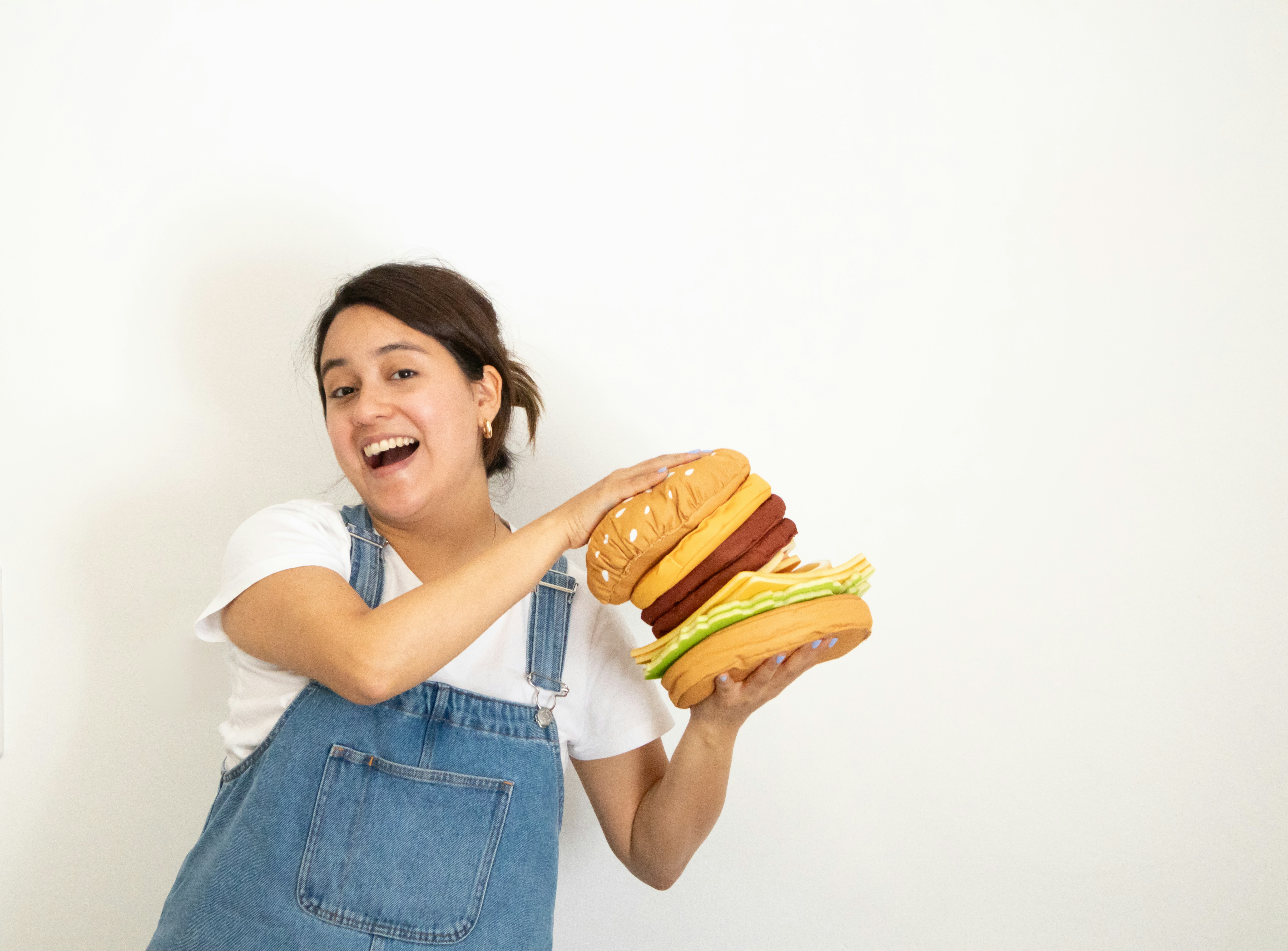 Una mujer en mono sosteniendo un sándwich grande foto – Imagen de Feliz ...