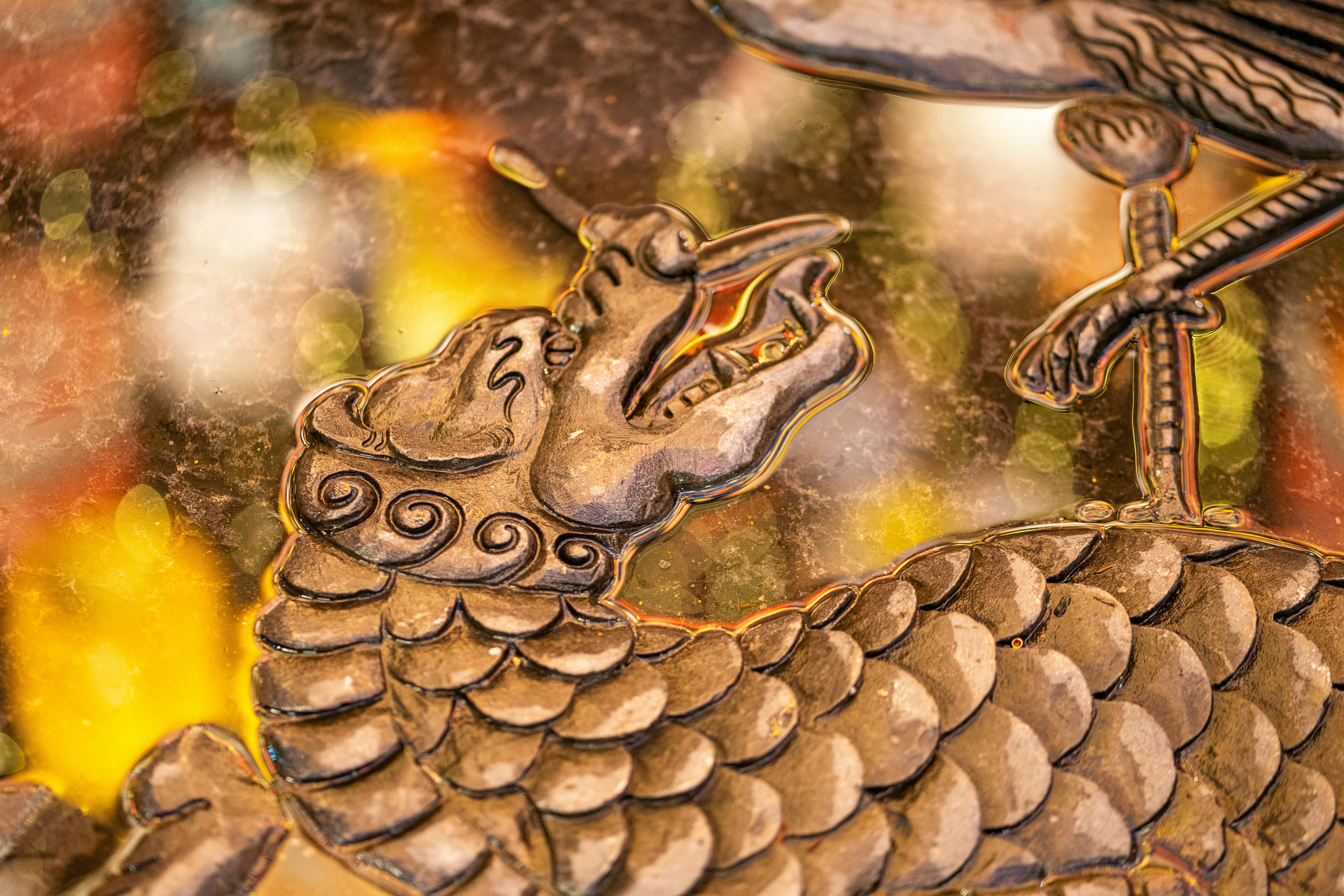 Dragon Emblem in Warm Glass: Close-Up of Ornate Carving