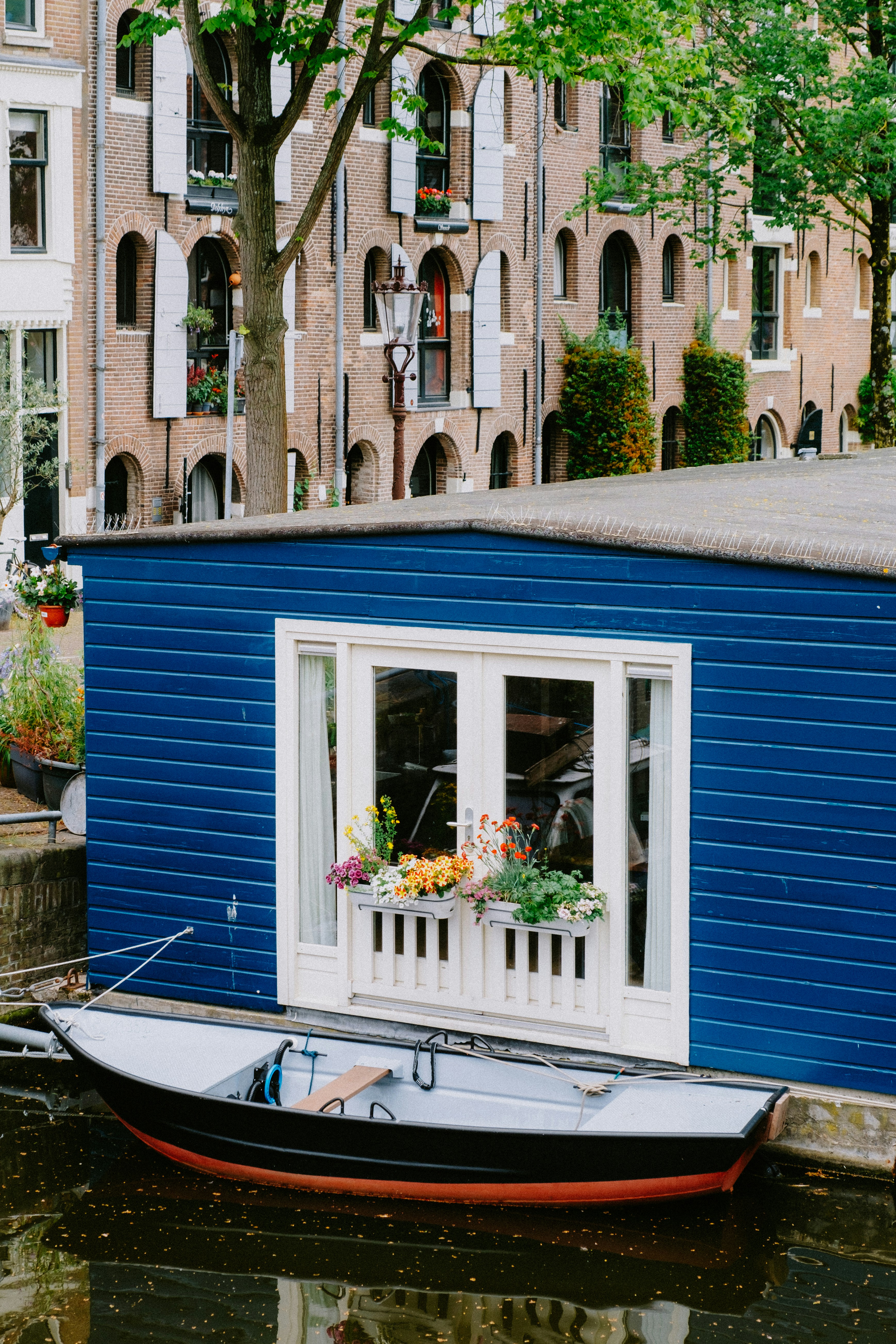 Azure Canal Houseboat: Window Box of Color Framing a Quiet Waterside Scene