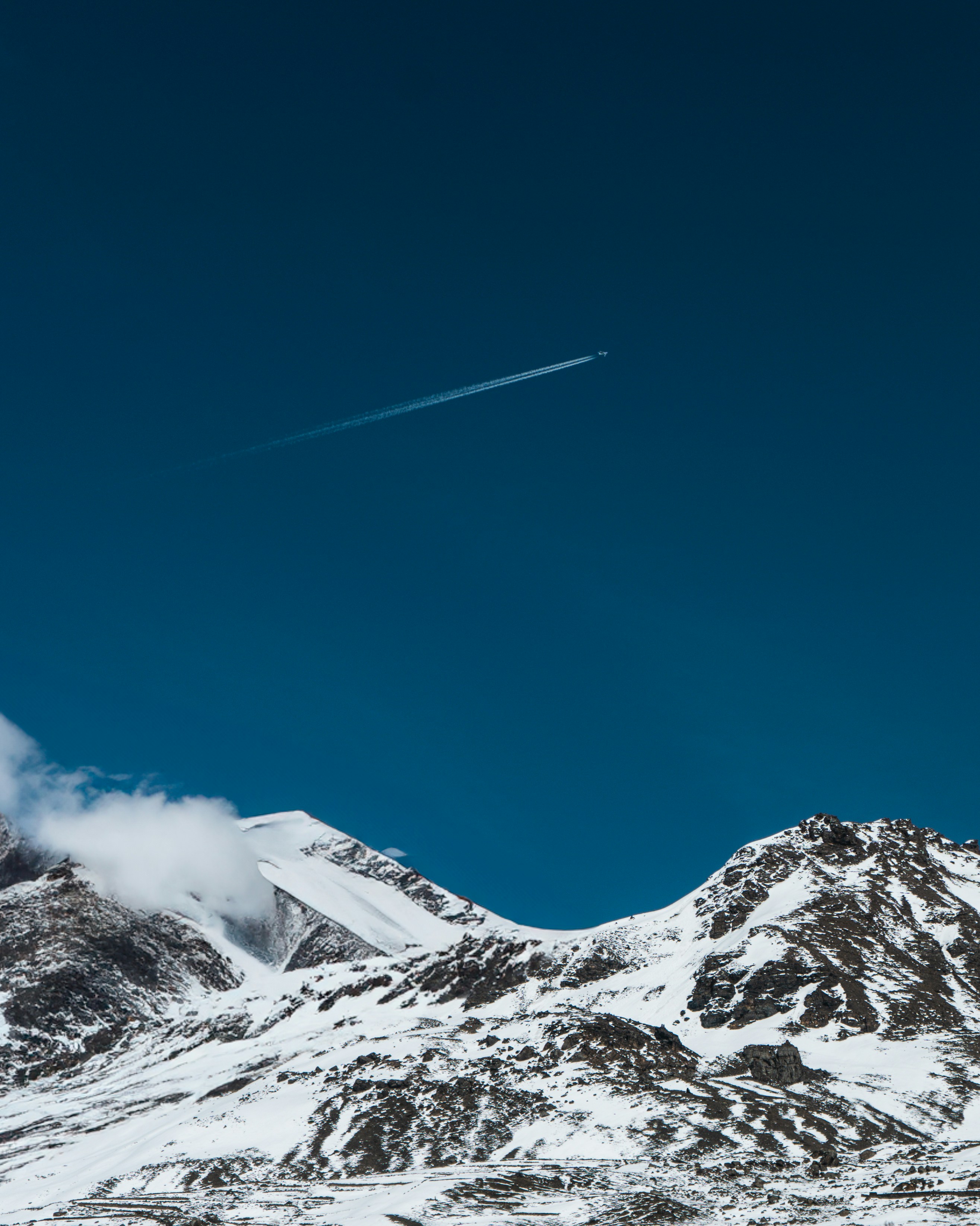 A plane flying over a snow covered mountain photo – Free Mounatins ...