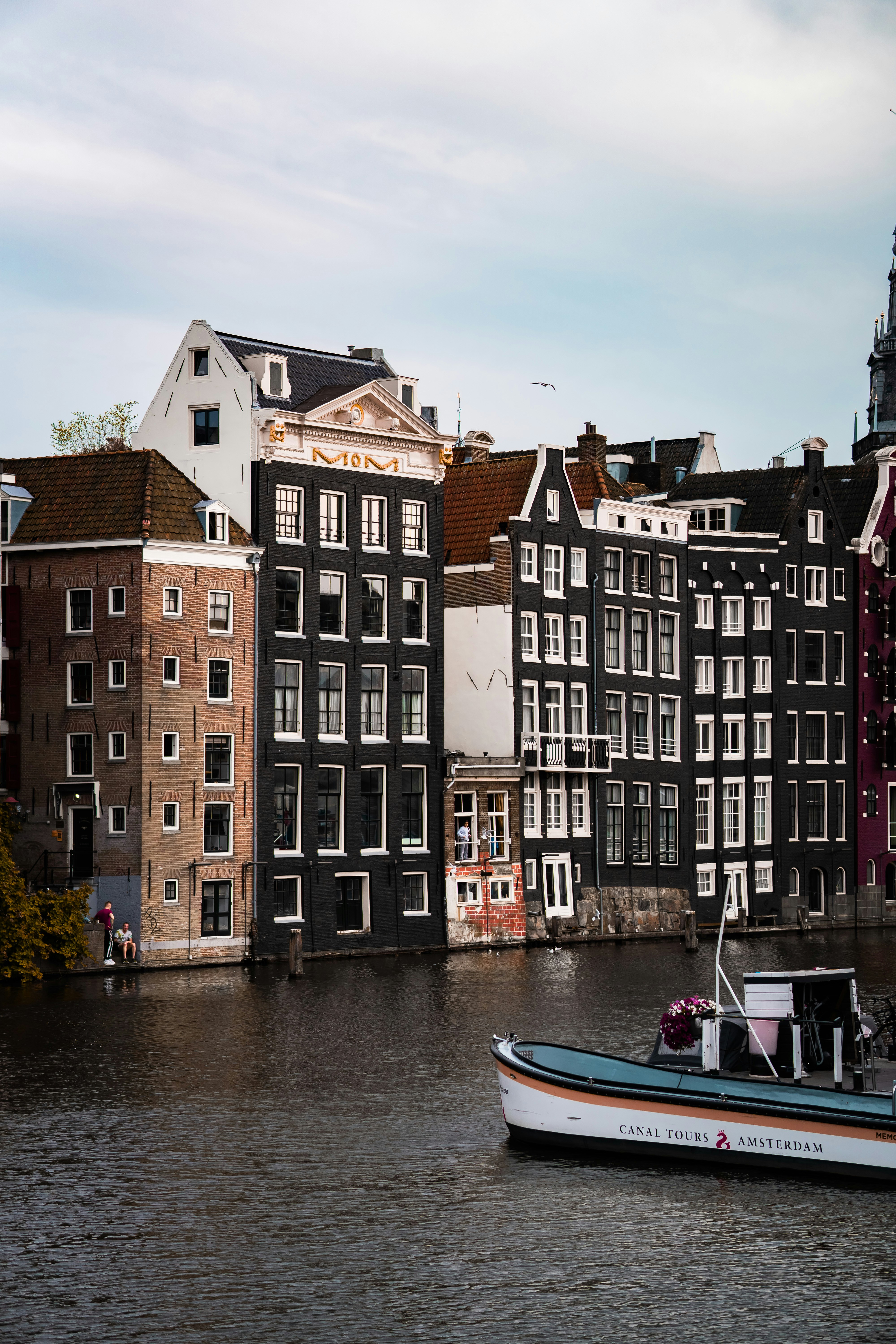 Boat docked in Damrak during sunset
