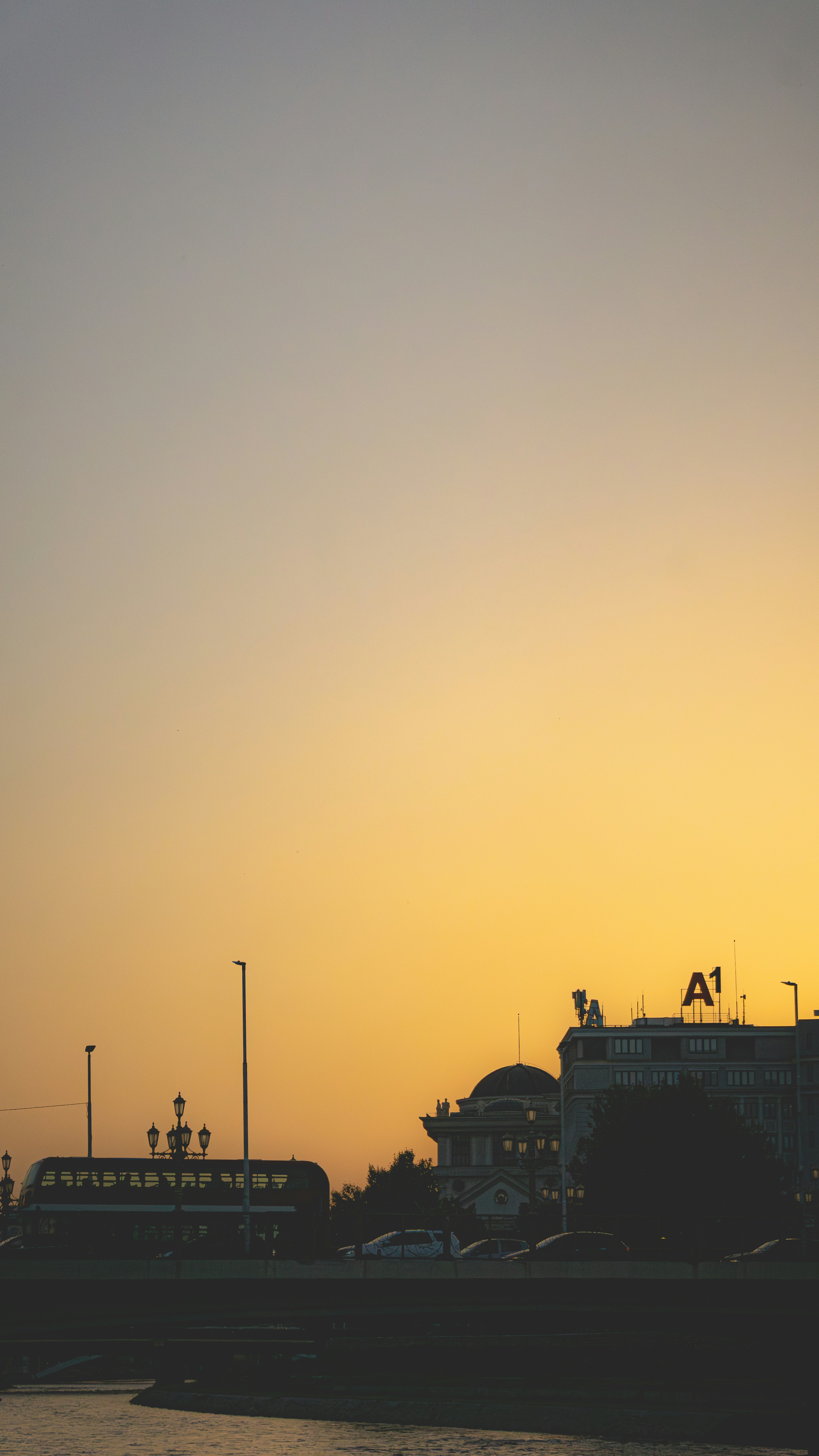 The sun is setting over a city with a train on the tracks photo – Free ...