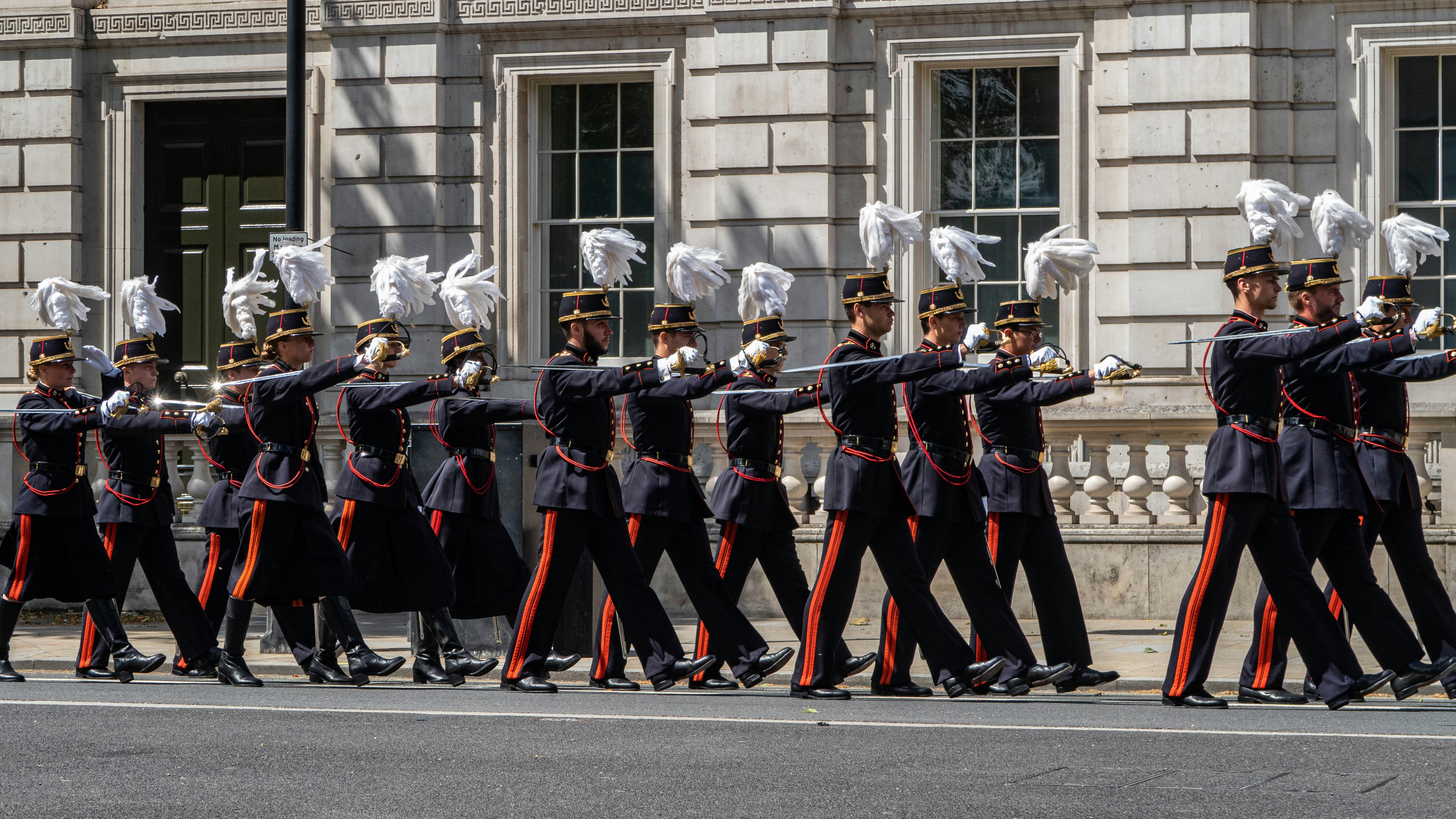 A group of men in uniform marching down a street photo – Free Woman ...