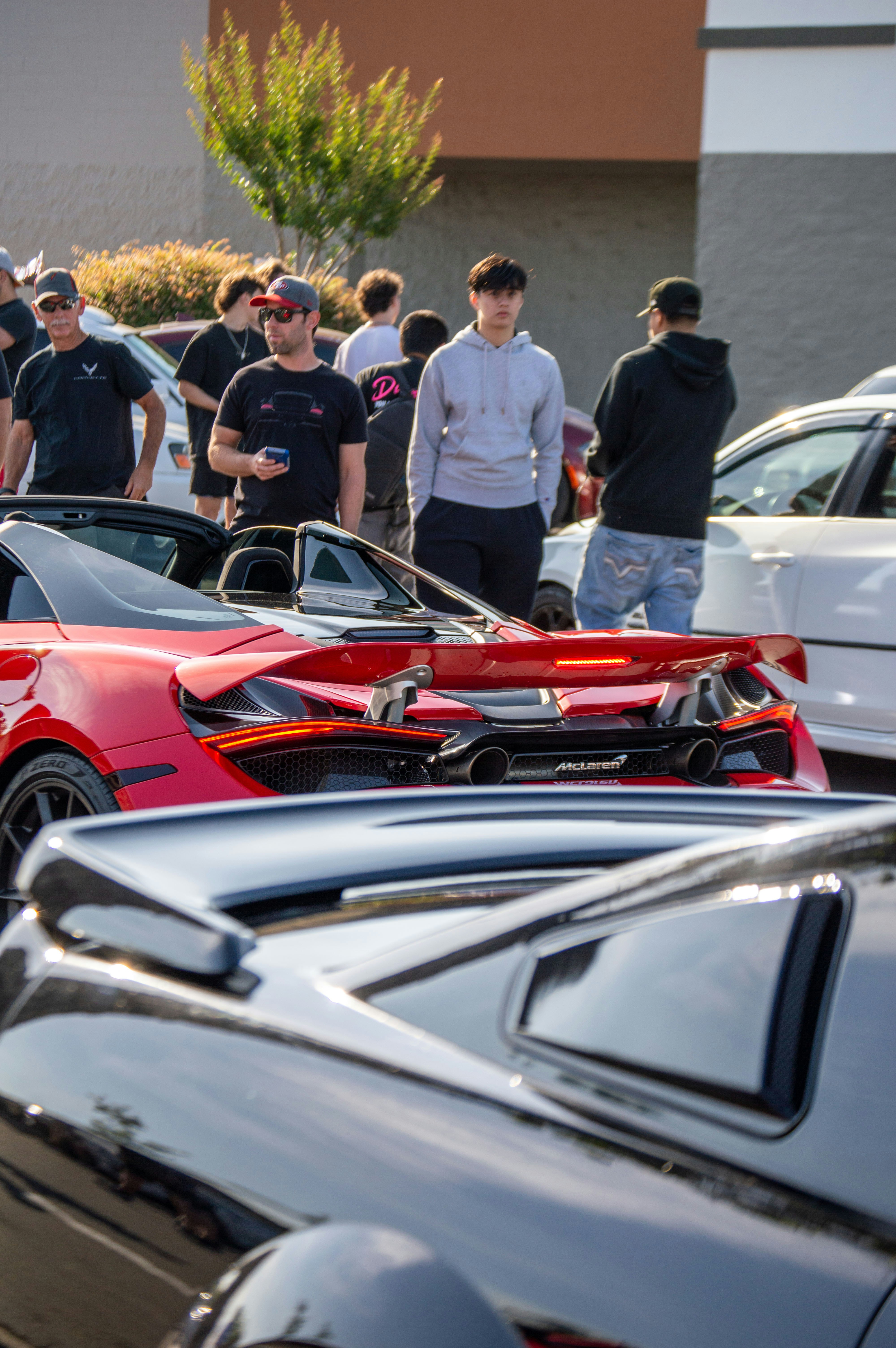 A group of people standing around a bunch of cars photo – Free Car ...
