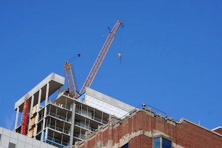 Arc of Steel: Crane Over a Brick-Fronted Cityscape